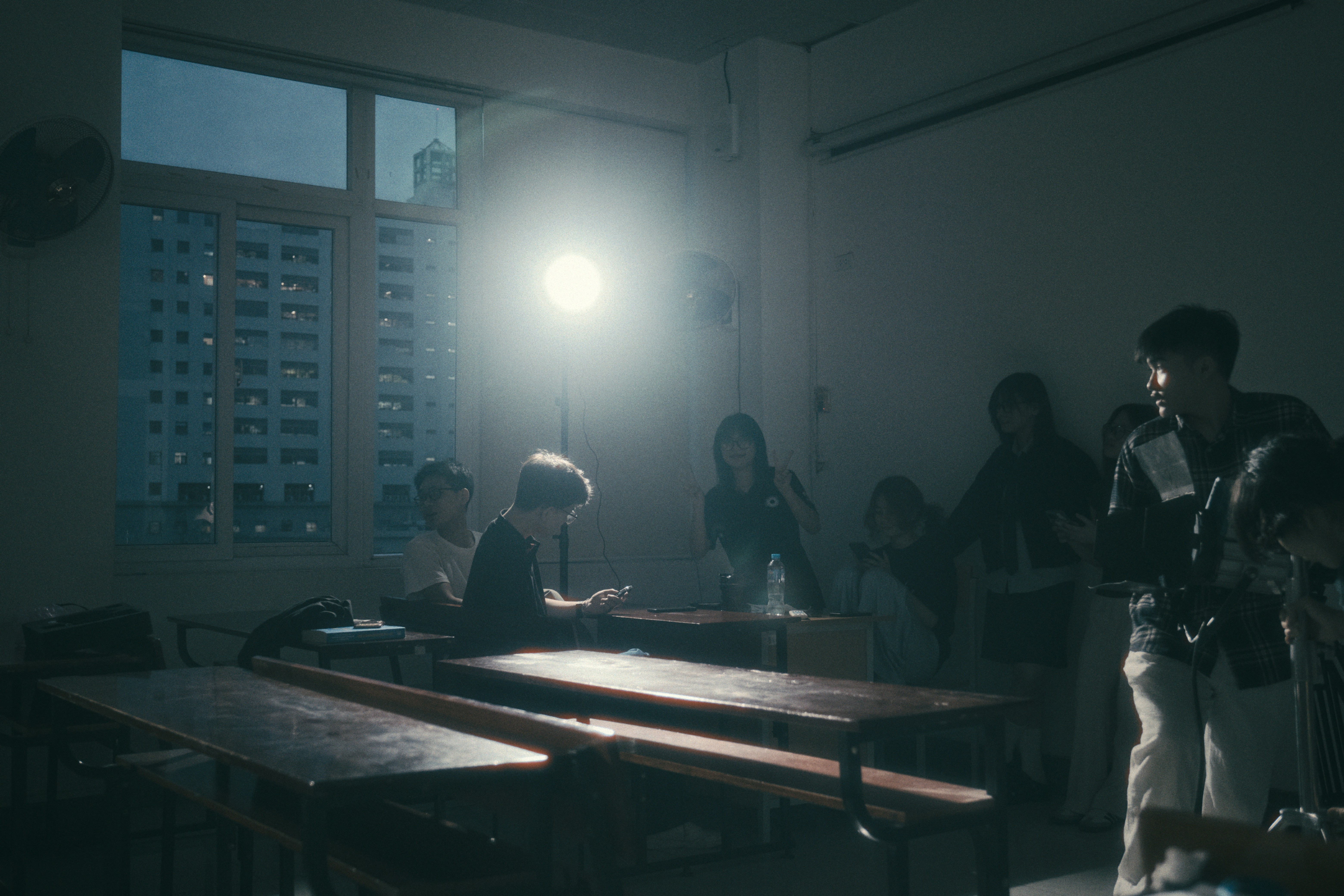 A group of people sit in a dimly lit classroom. photo – Free Woman ...
