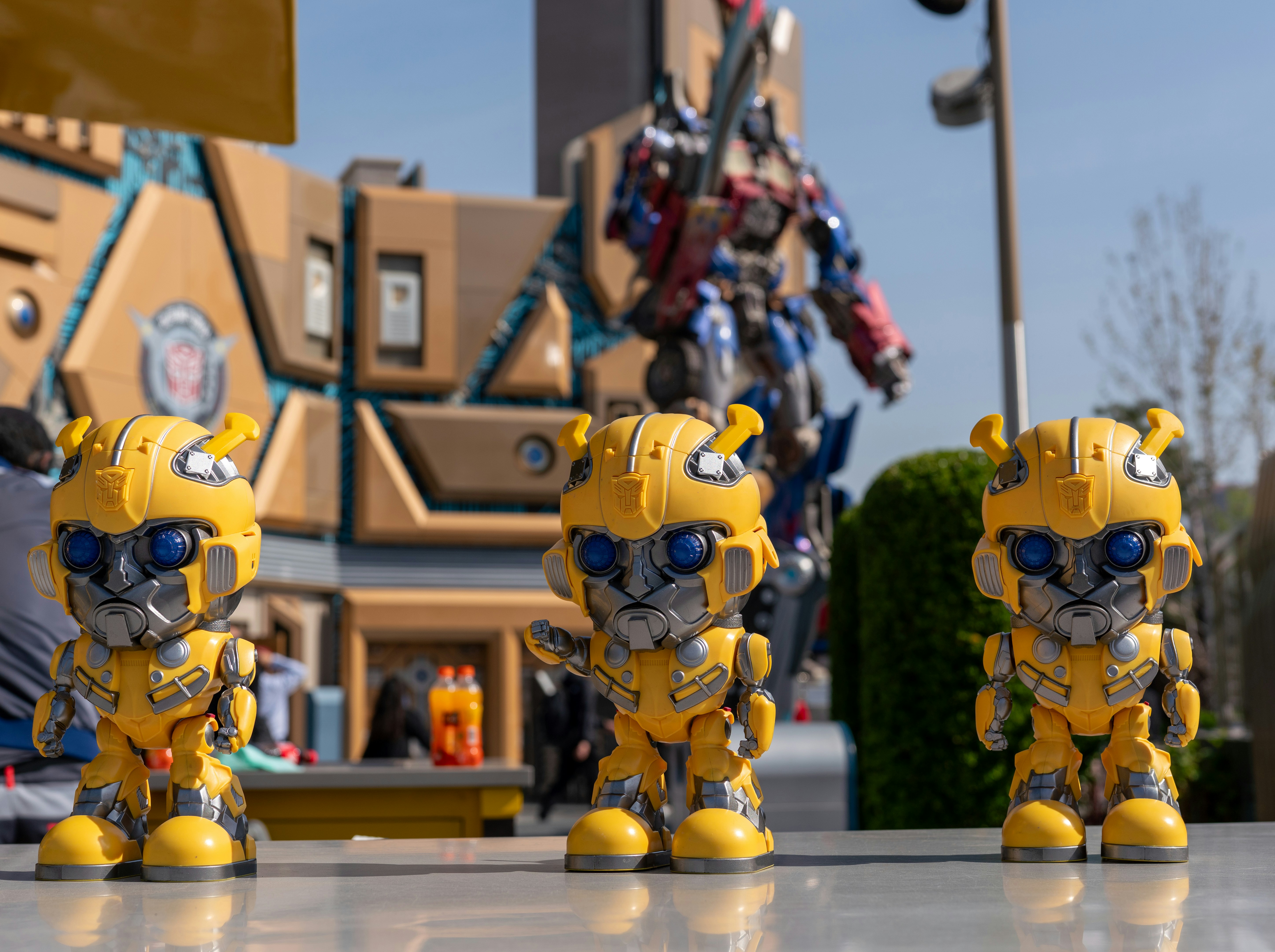 Three Yellow Transformers: Toy figures guard a futuristic backdrop