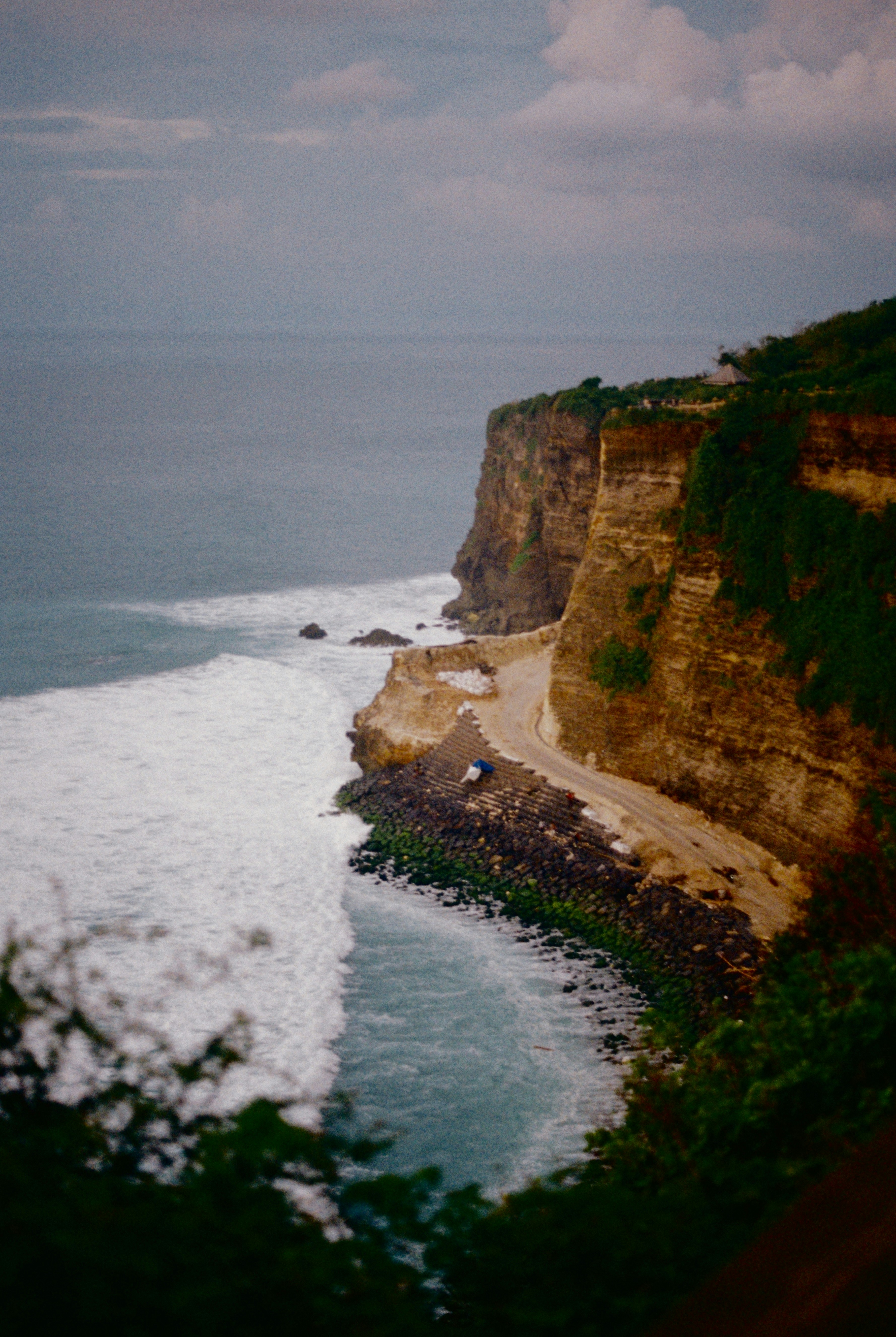 Cliffs meet the ocean along a coastal road. photo – Free Travel Image ...