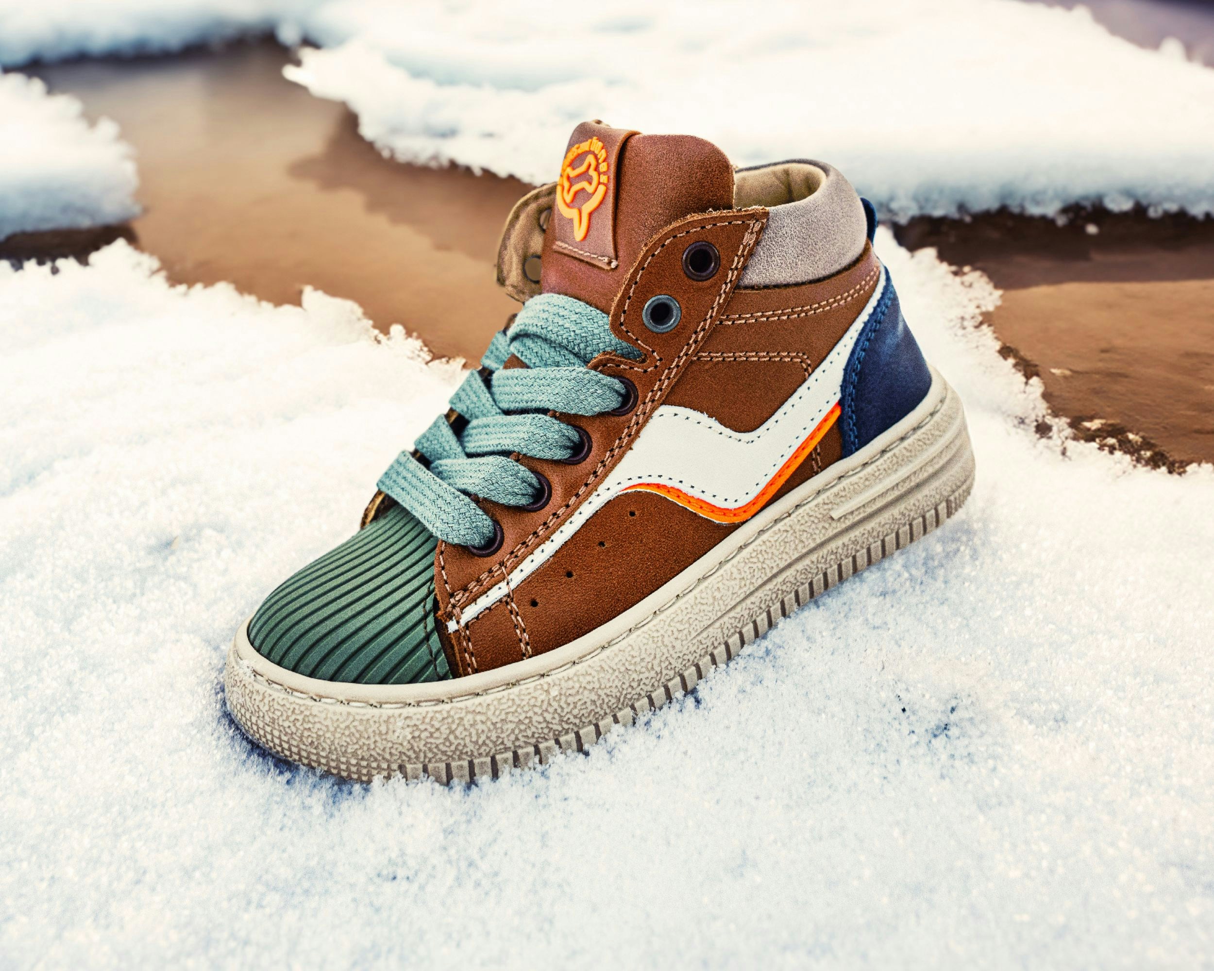 A stylish sneaker sits on a snowy ground. photo – Free Shoe Image on ...