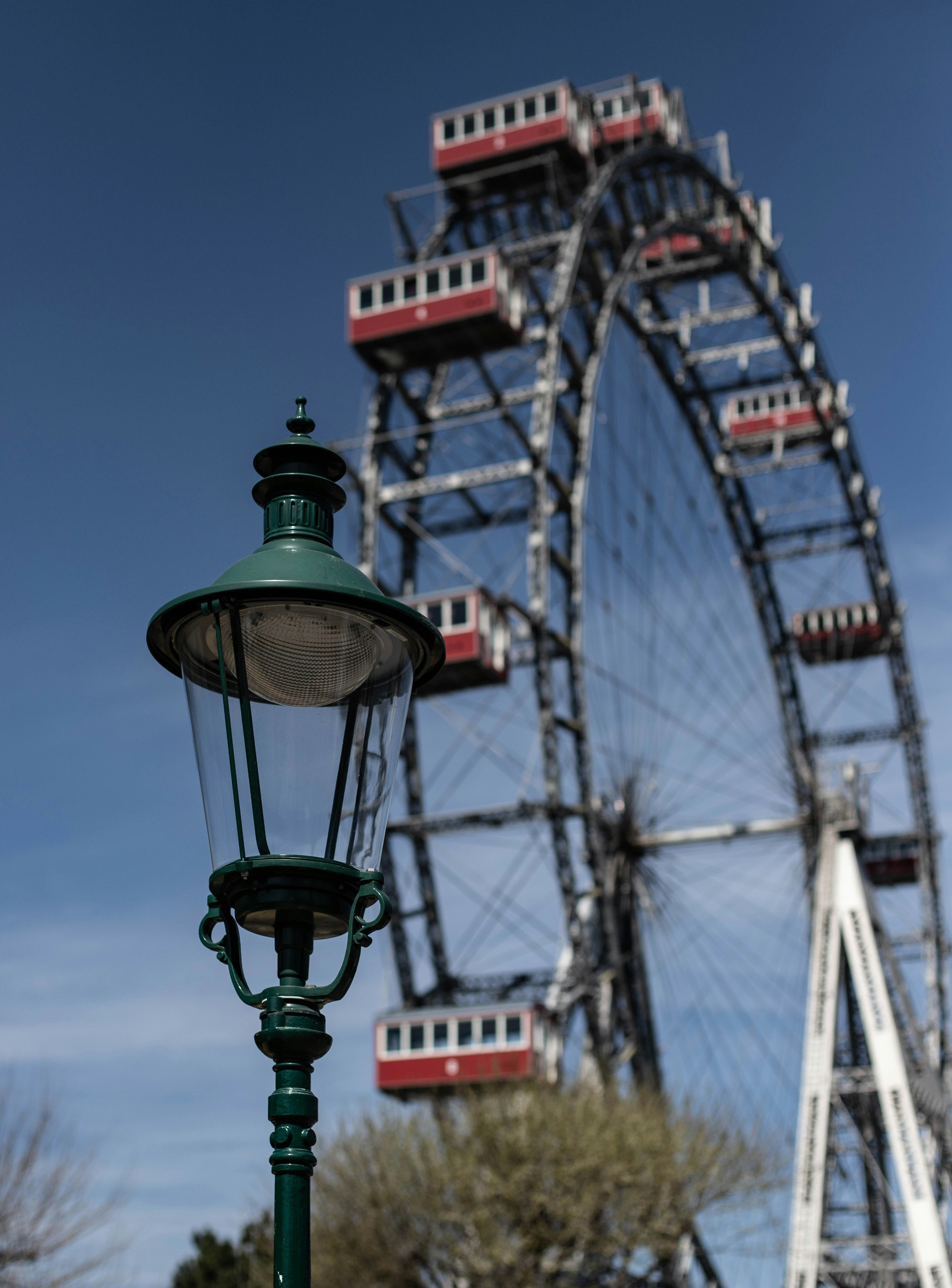 Emerald Streetlamp in Foreground, Framing a Towering Ferris Wheel