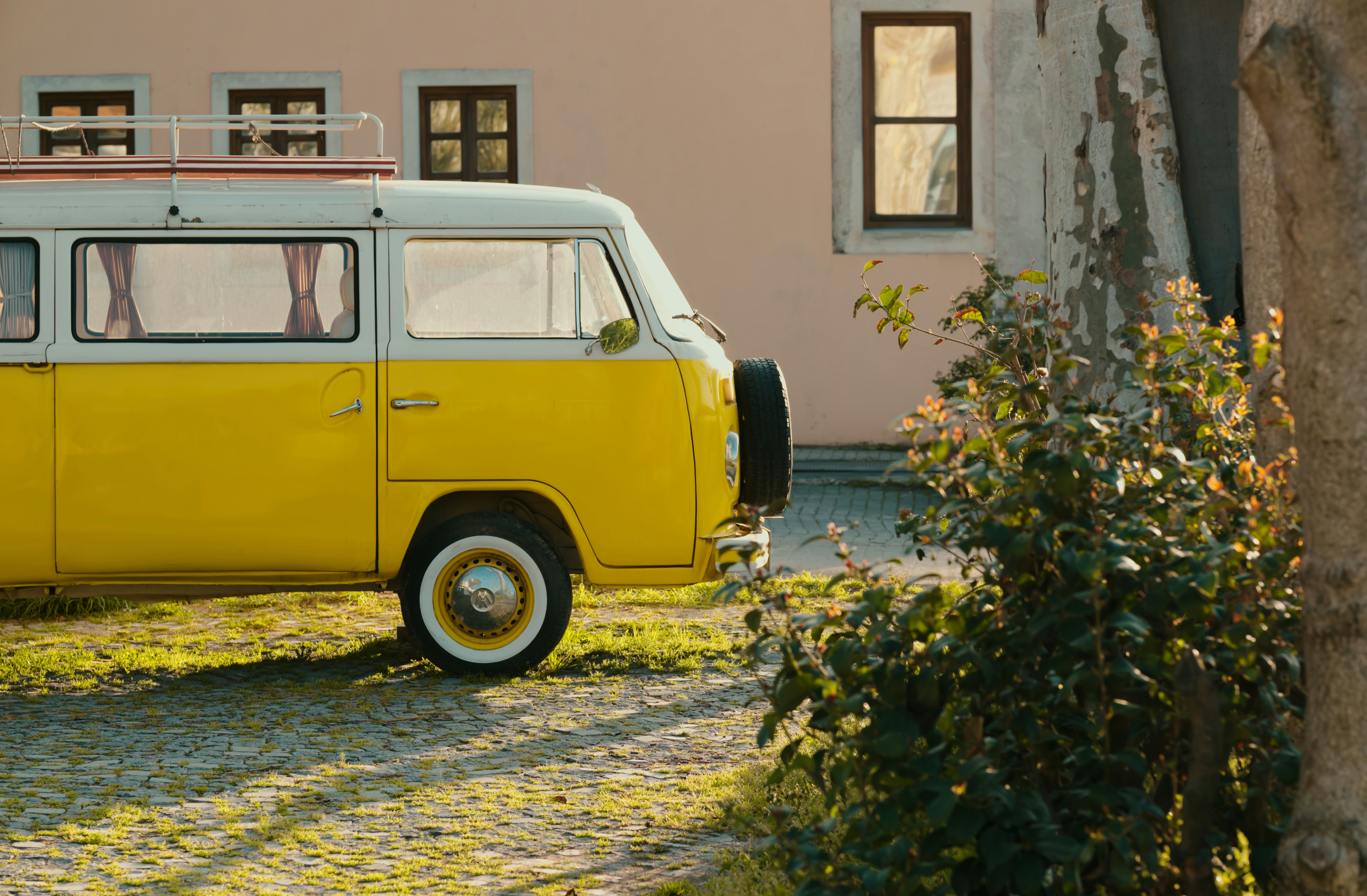 A yellow volkswagen van is parked near a building. photo – Free Car ...