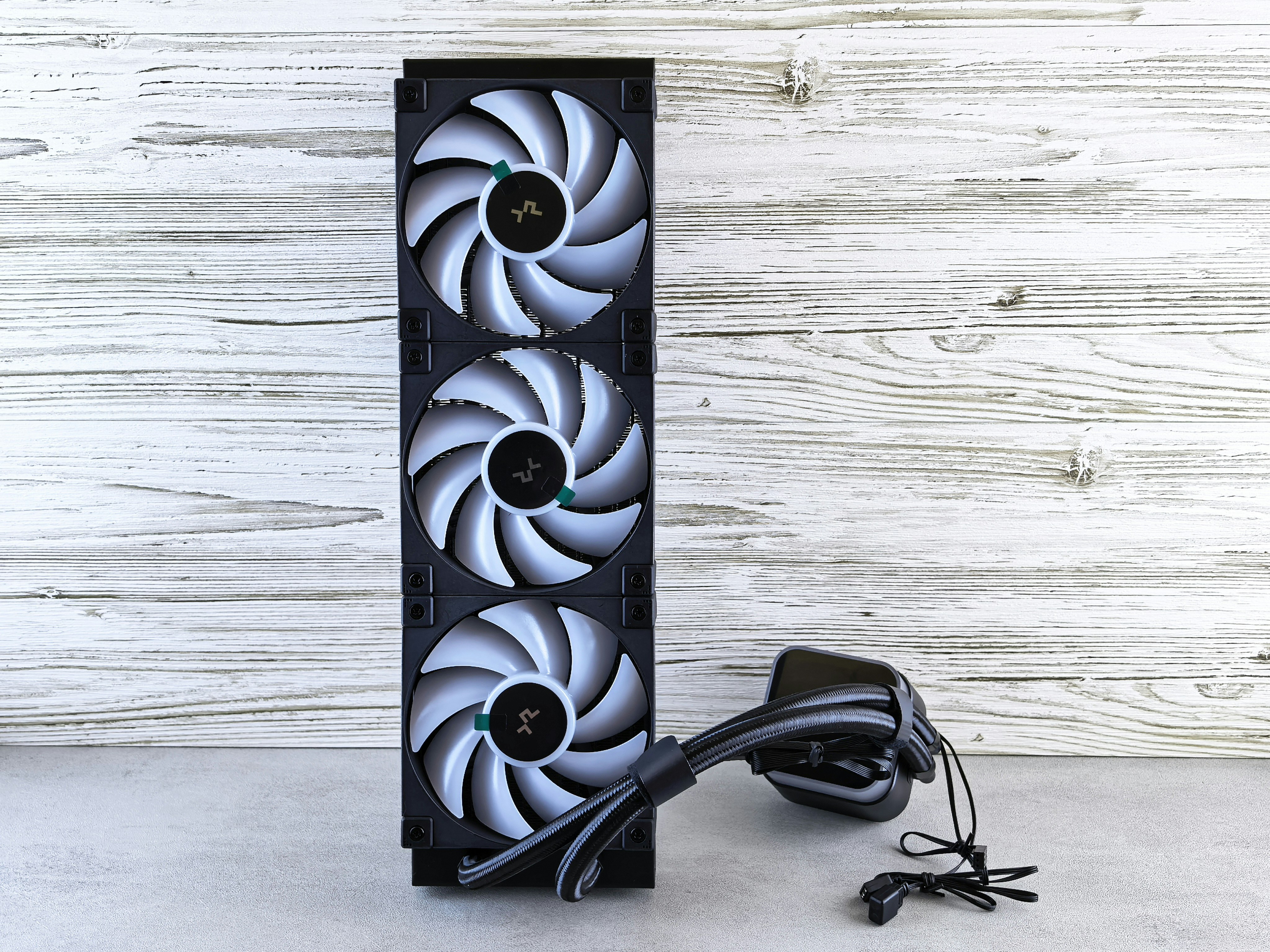 A triple-fan water cooler is shown against a light backdrop.