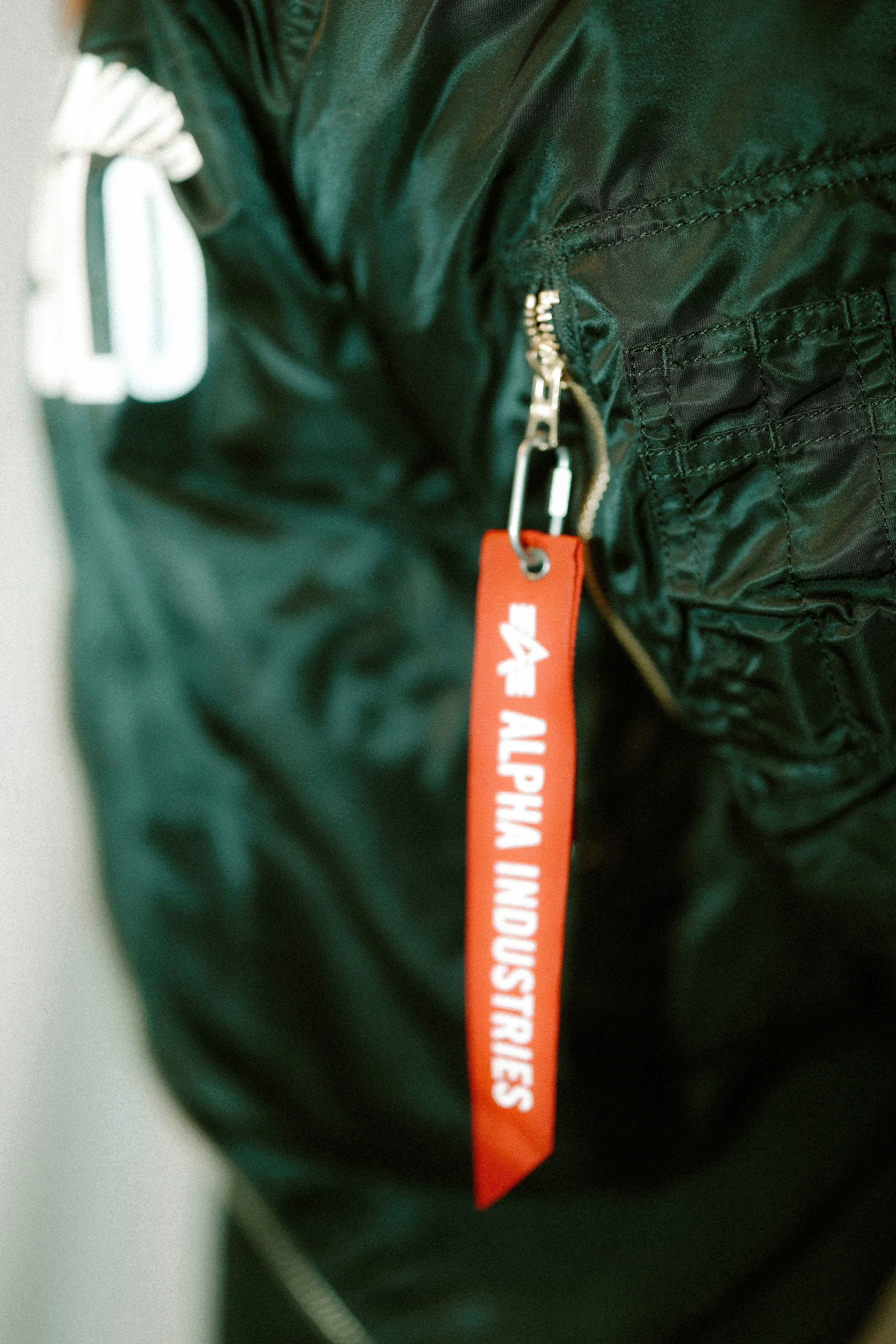 Close-Up of a Red Lanyard Tag Clipped to a Rugged Black Nylon Jacket