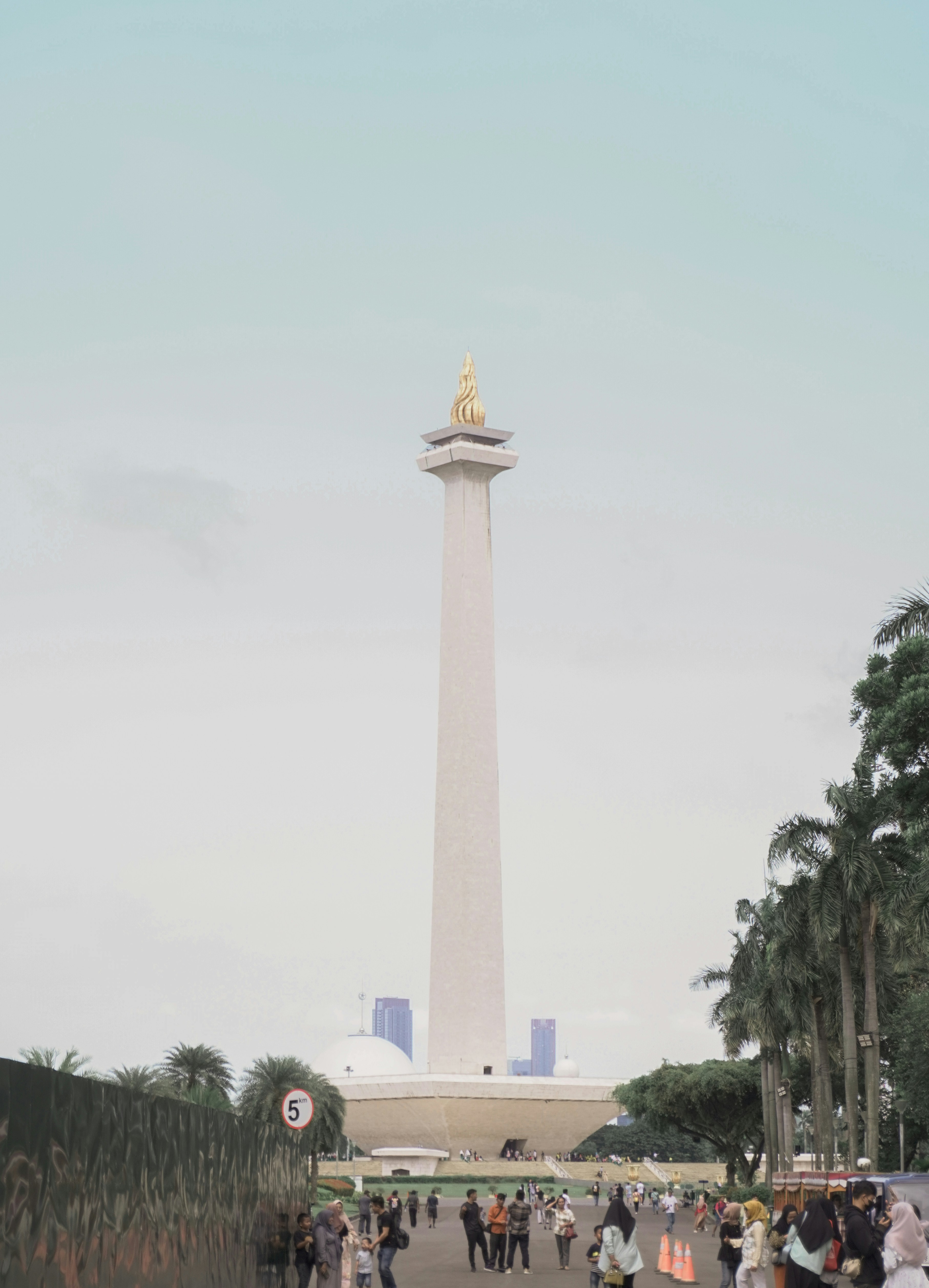 Gilded Spire Over a Palm-Lined City Plaza