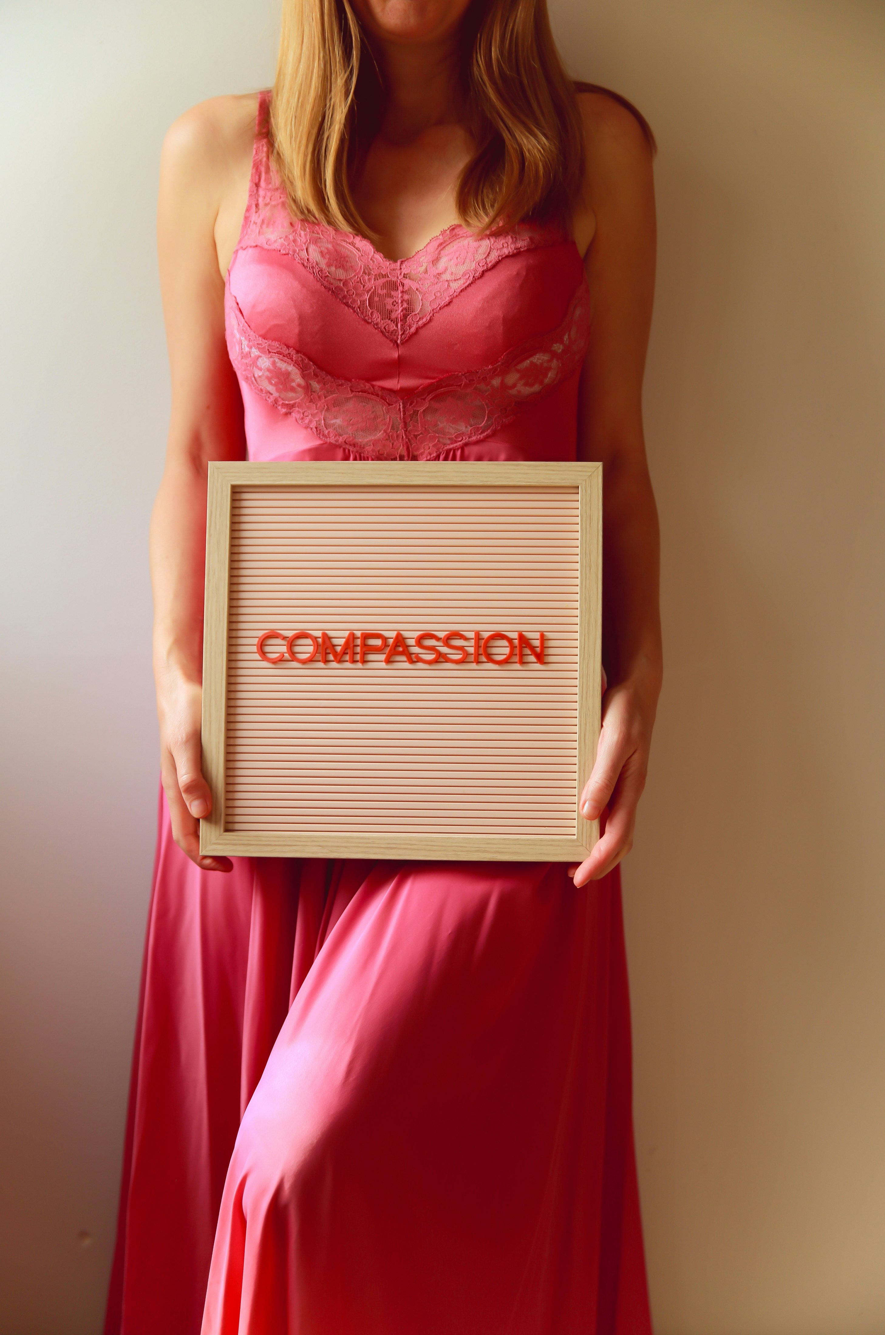 Woman holds a sign that reads "compassion." photo – Free Woman Image on ...