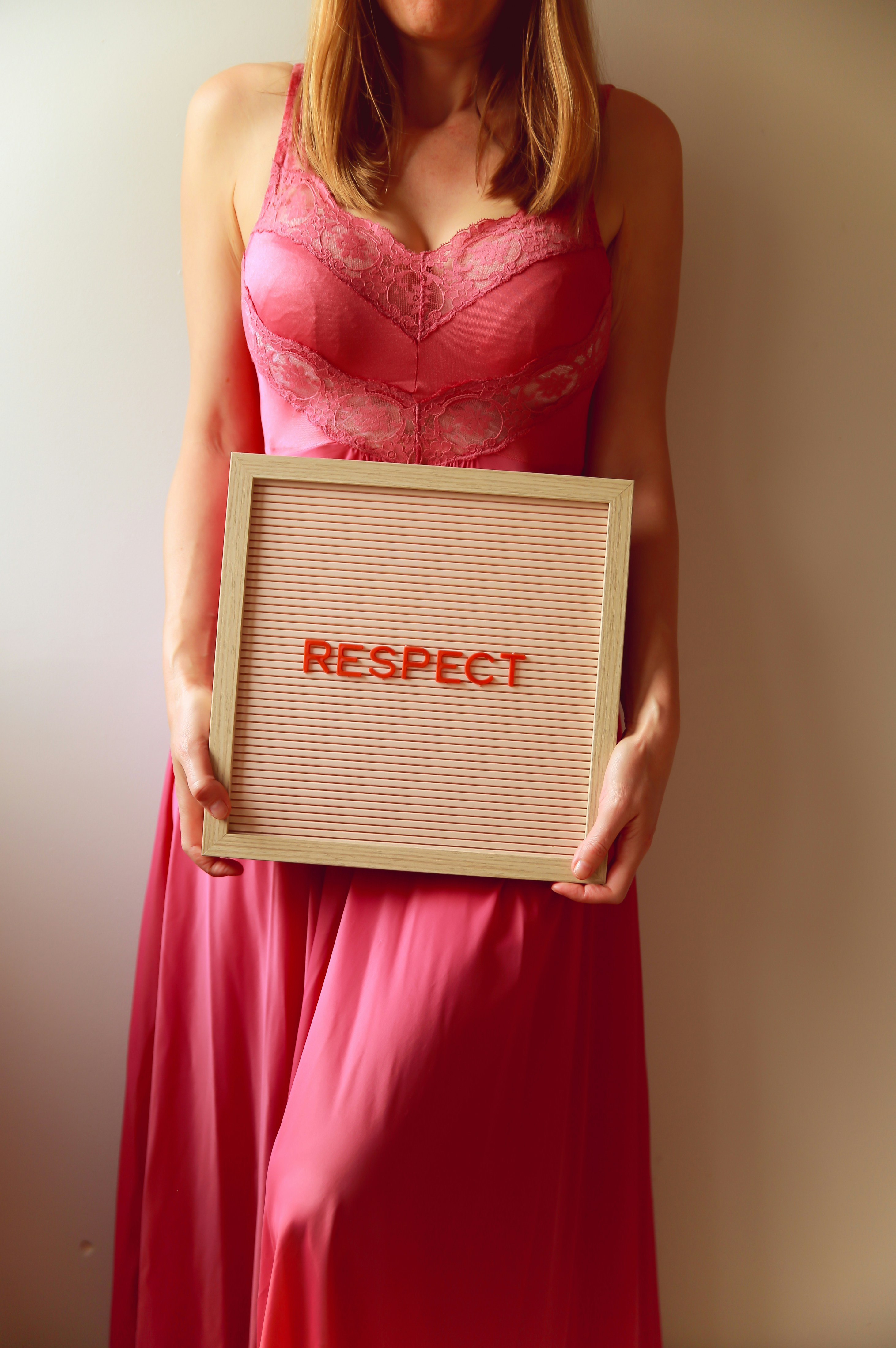 Woman in dress holds a sign that says "respect." photo – Free Woman ...