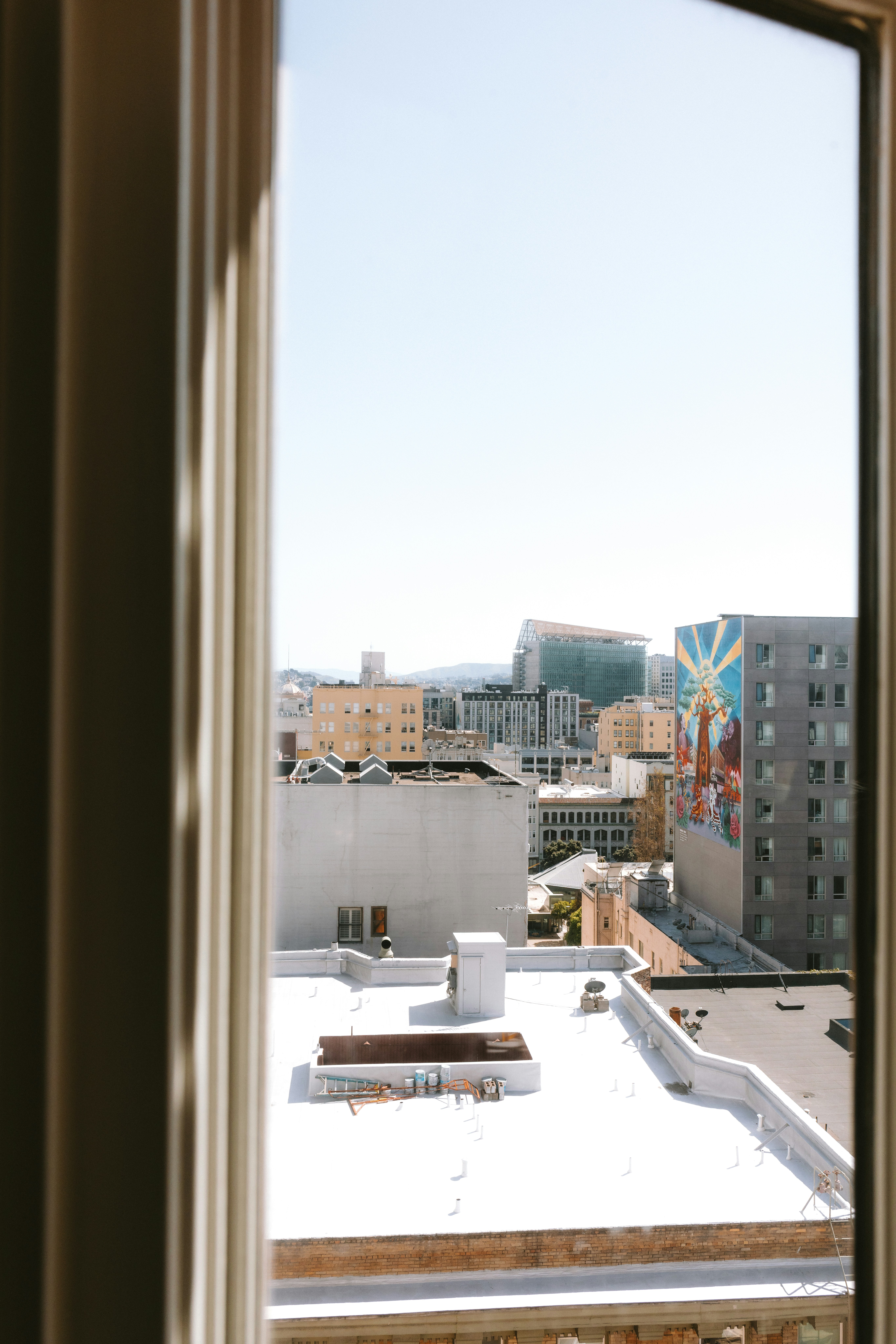 Edificios de la ciudad vistos a través de una ventana iluminada por el sol. foto – Imagen de San ...