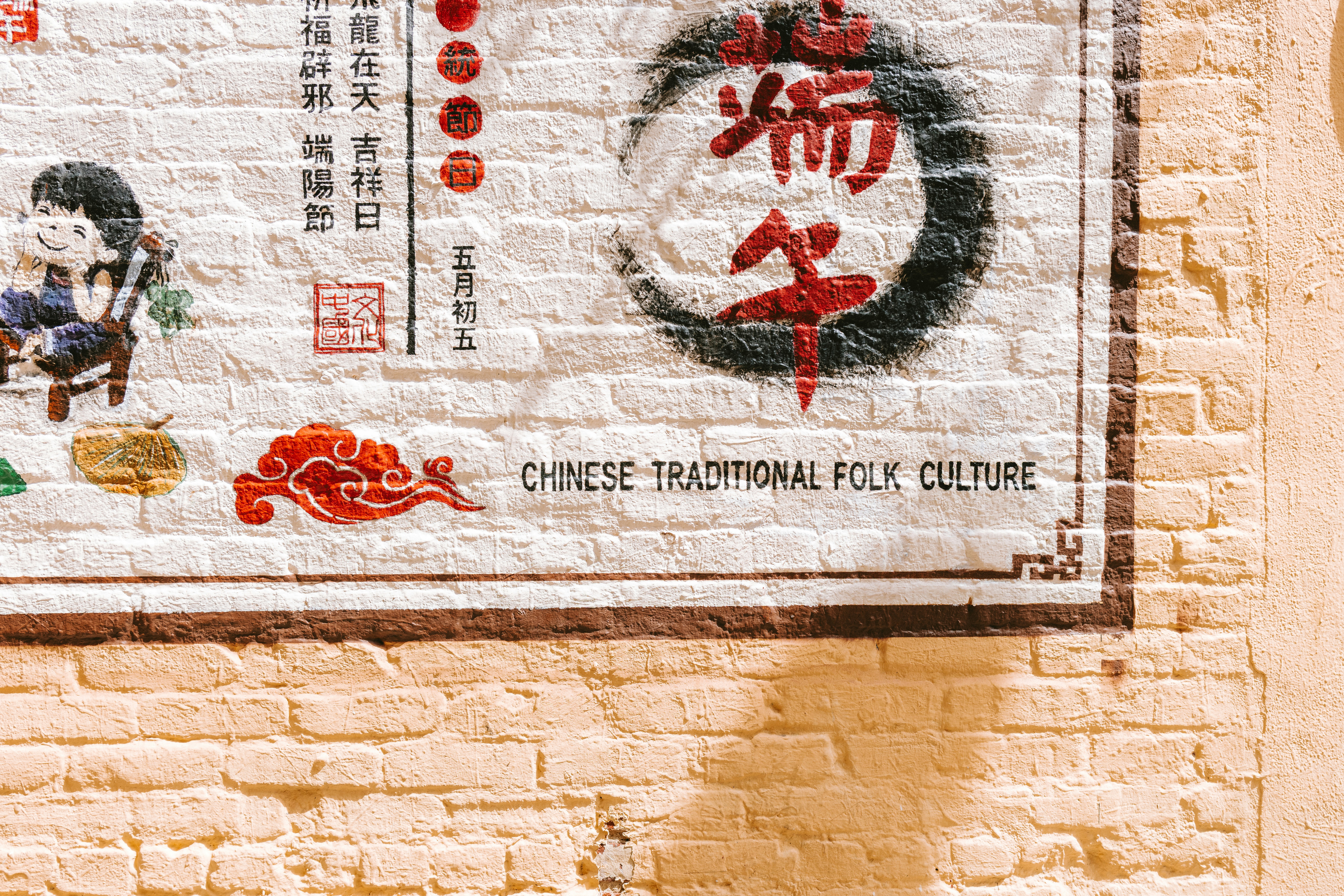 Chinese-themed mural with text and images on brick. photo – Free San ...