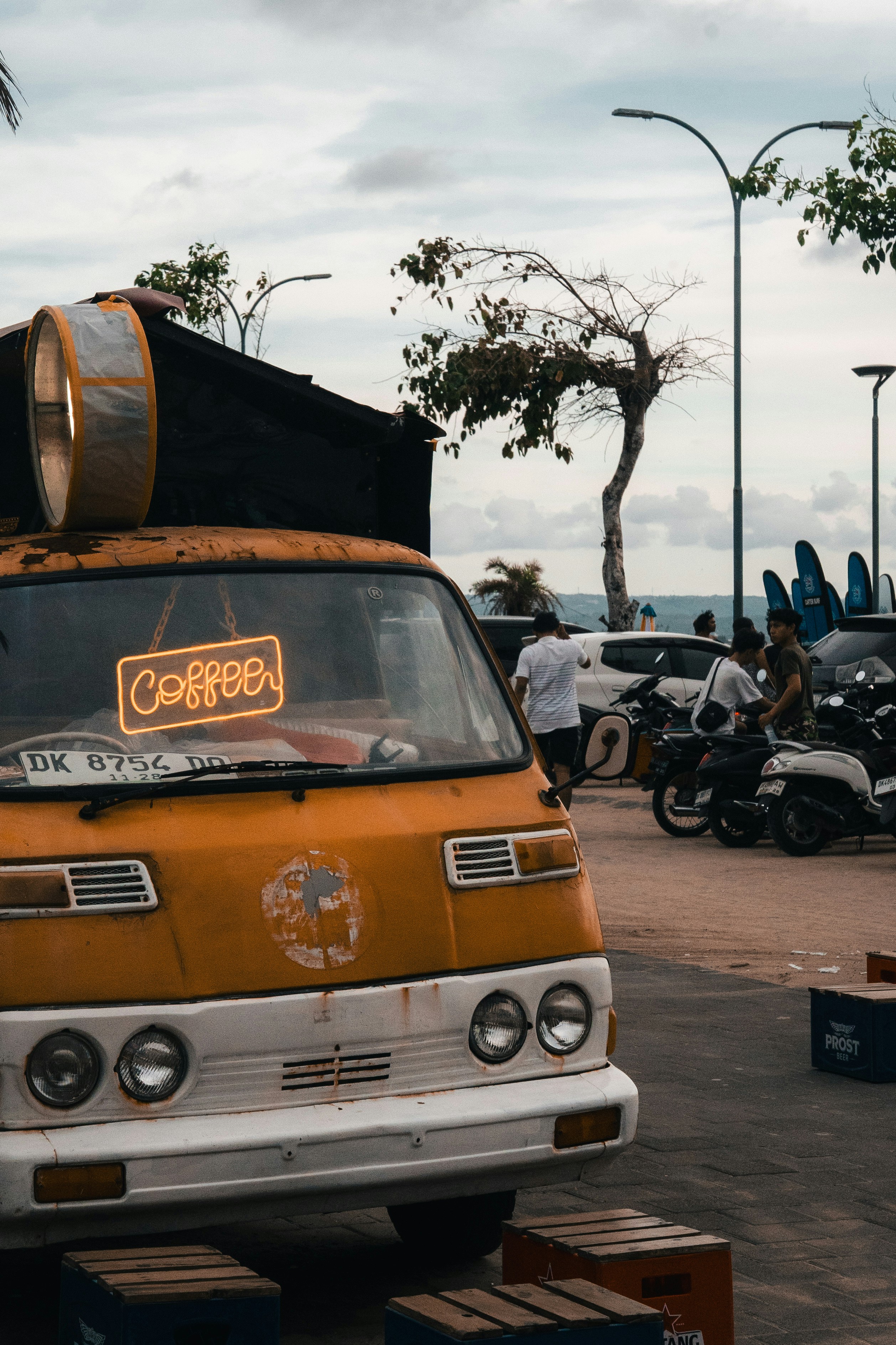 Yellow Coffee Van at the Marina: Neon Glow Through a Busy Street