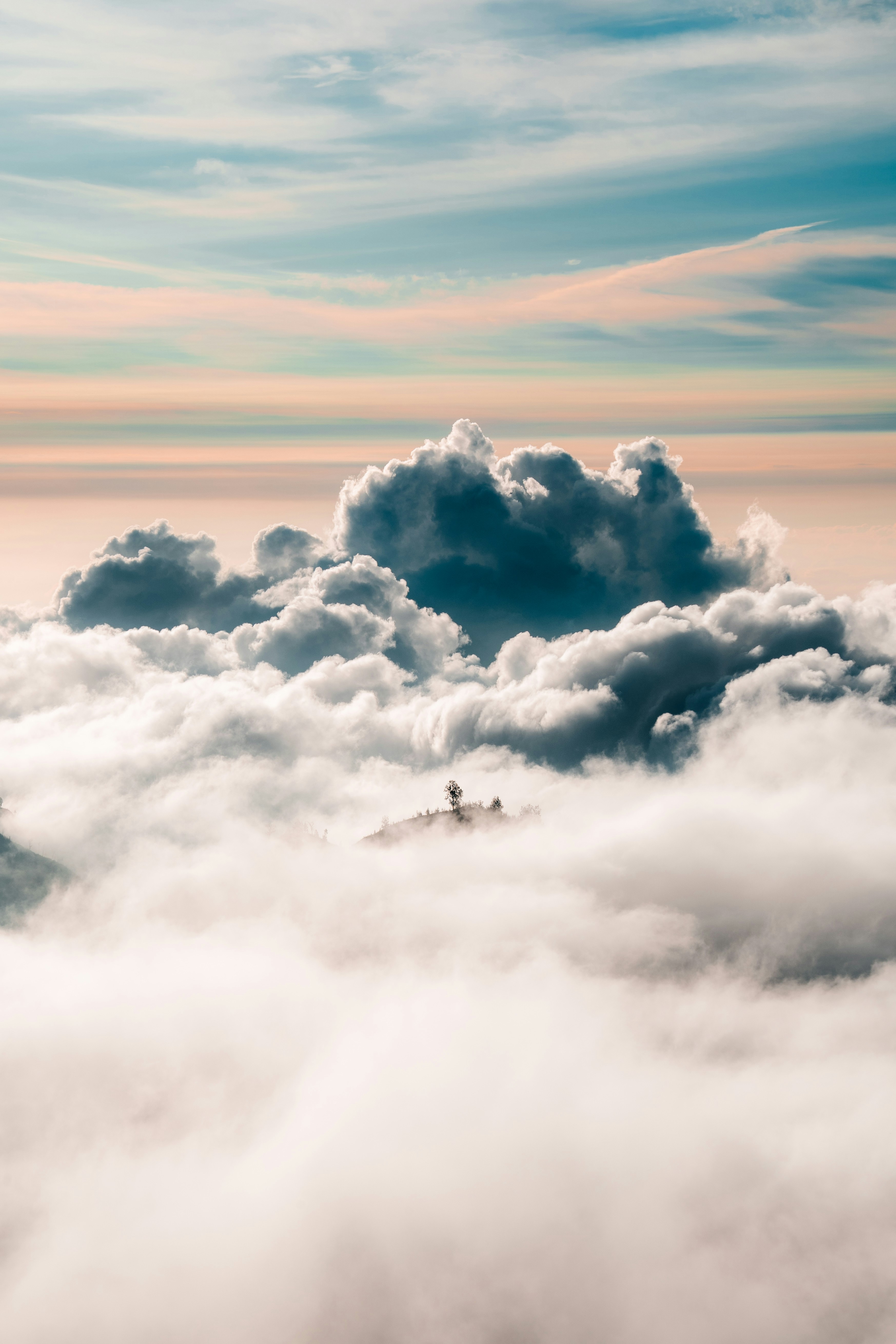 Clouds envelop a structure, reaching towards the sky. photo – Free ...