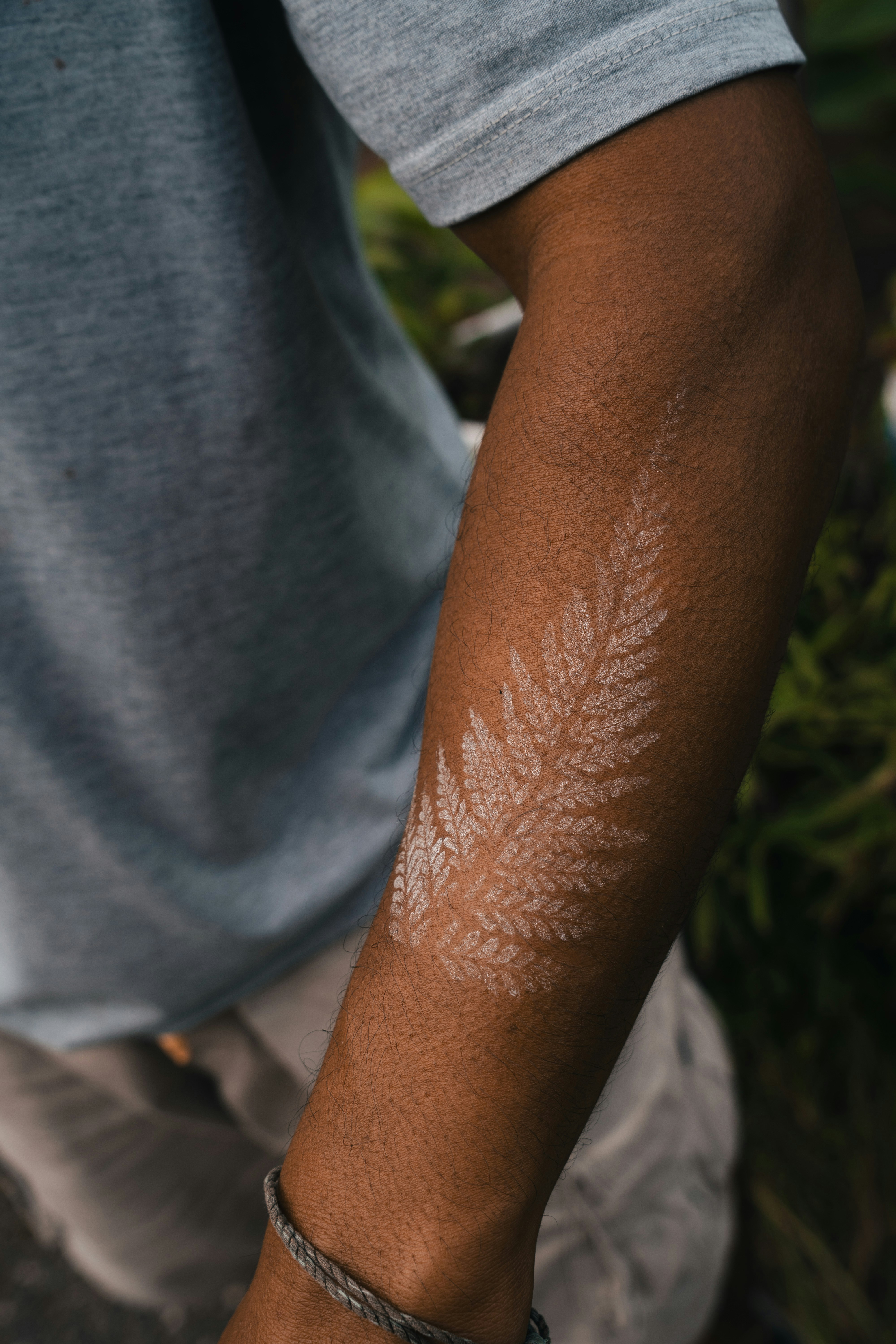 White Fern Tattoo Traced on a Sunlit Forearm