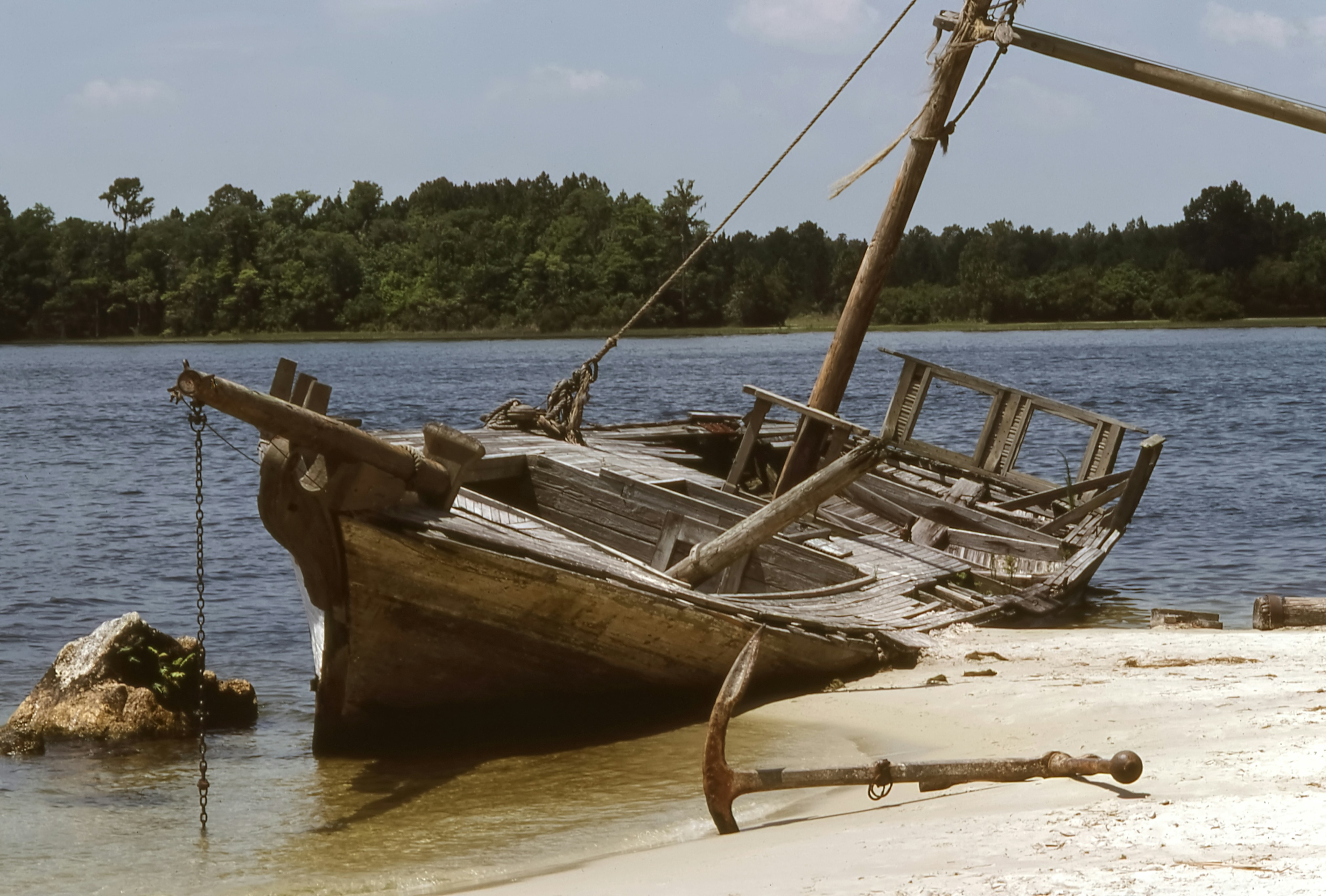 A dilapidated wooden boat rests on a sandy shore. photo – Free Beach ...