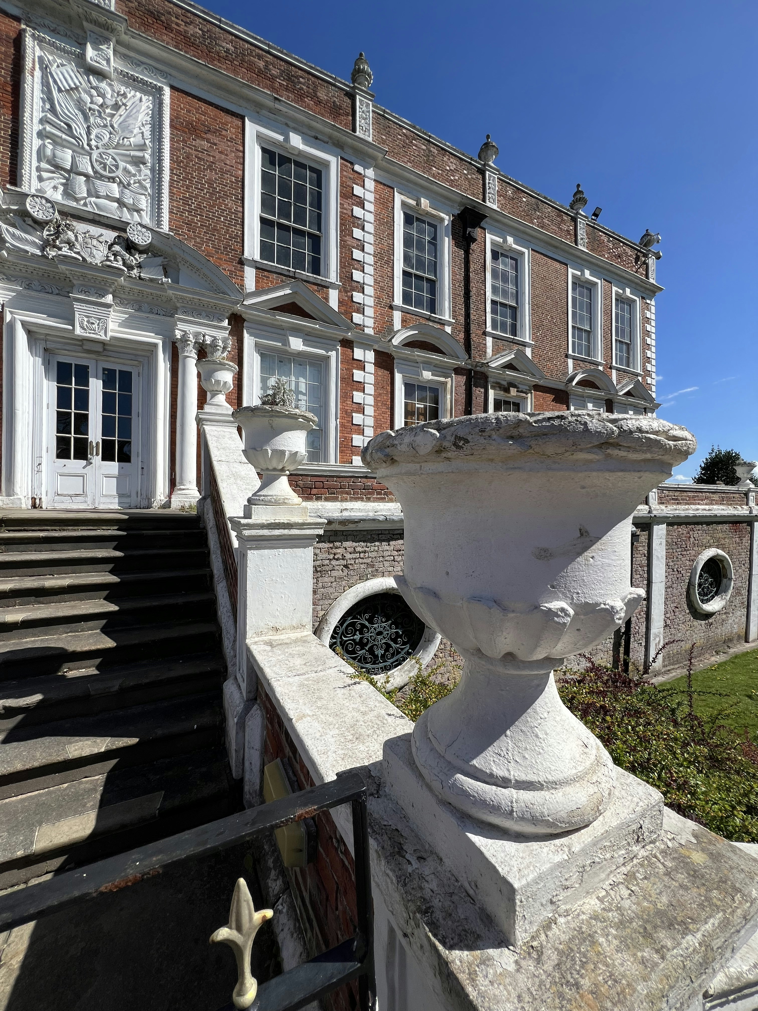 Urn in the Foreground: A Sunlit Staircase to a Georgian Brick Manor