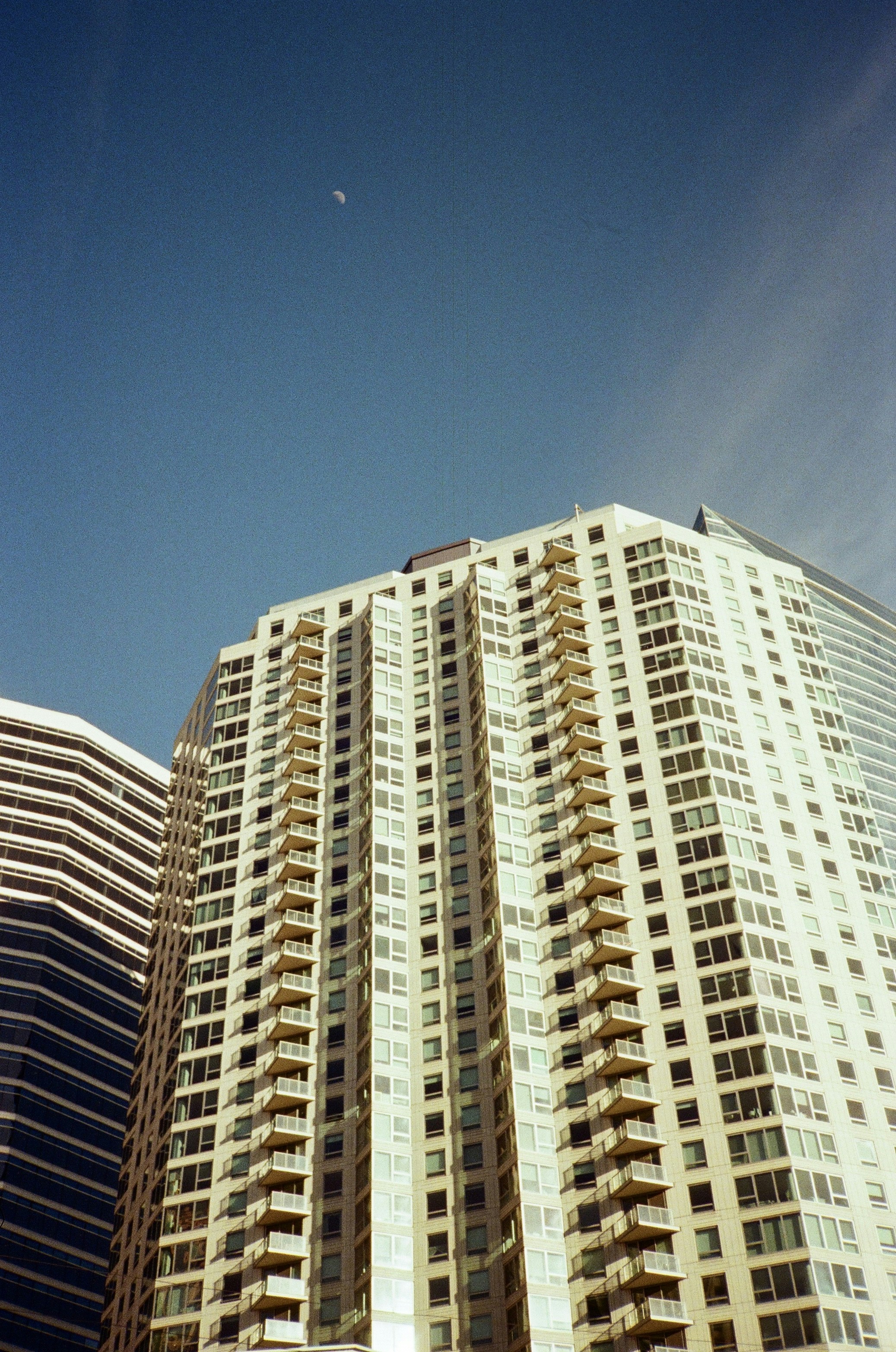Tall buildings stand against a bright blue sky. photo – Free City Image ...