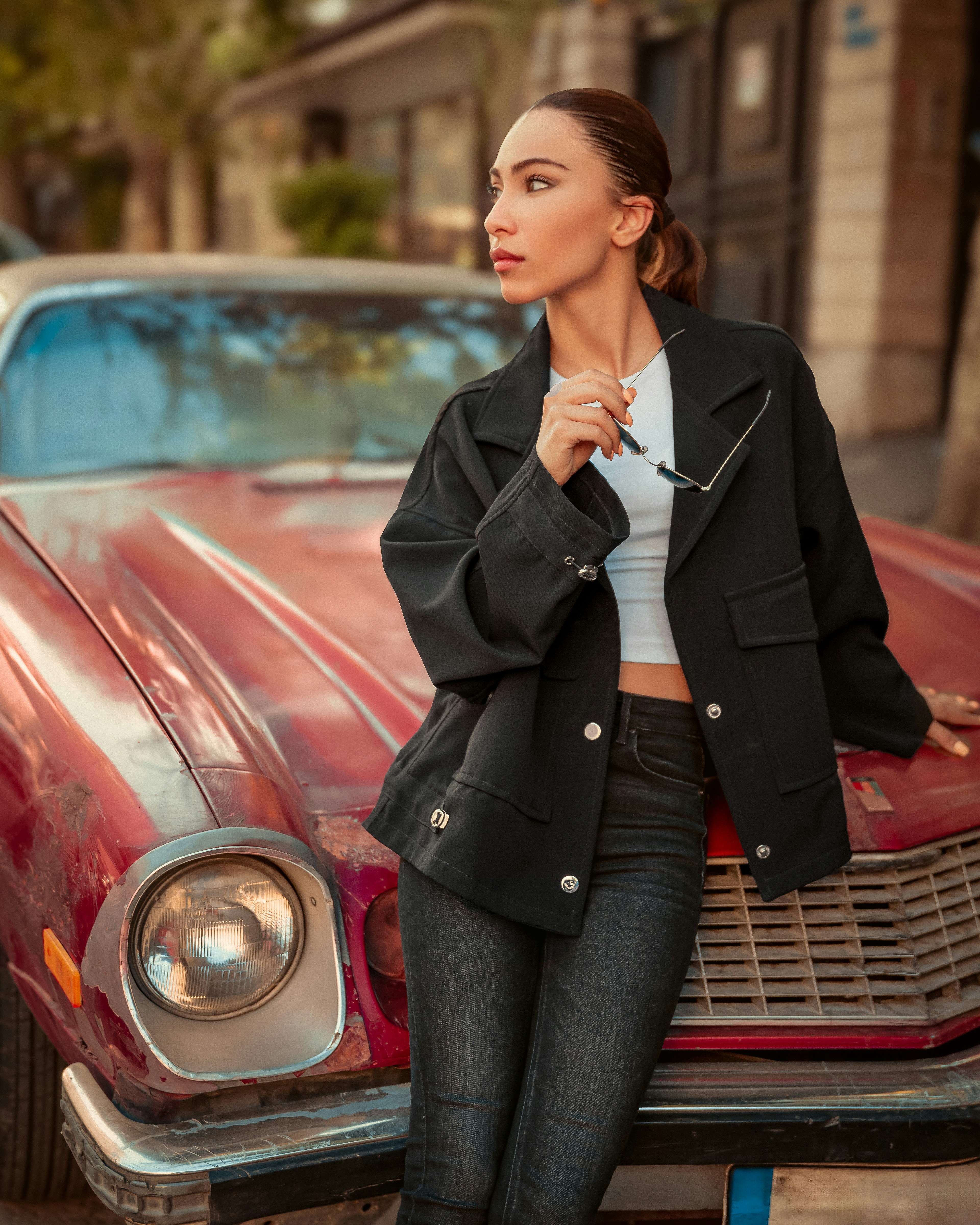 Crimson Chrome by a Vintage Cadillac: A Poised Street Portrait