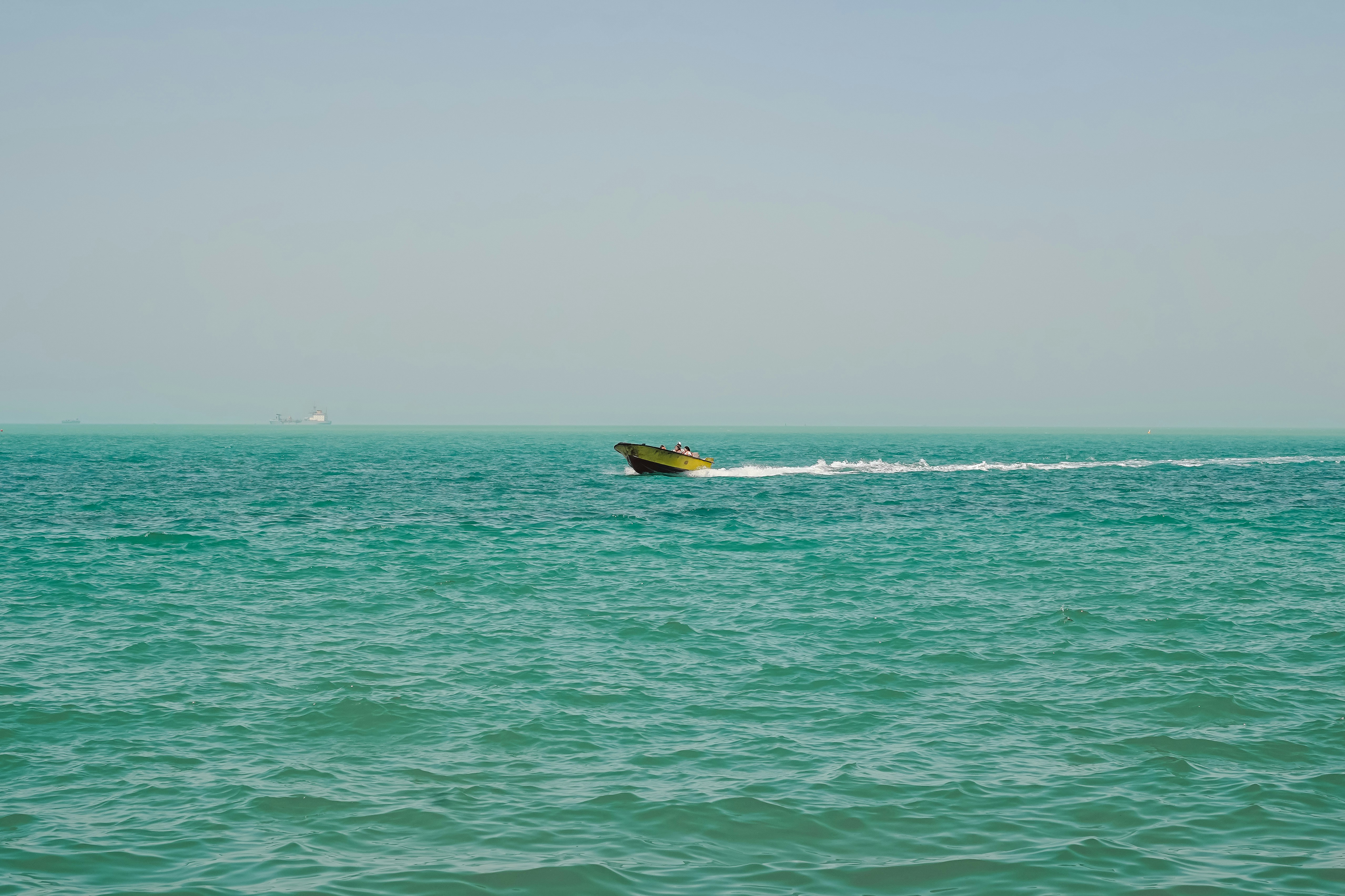 Teal Wake: A lone speedboat carving a wake across a tropical horizon