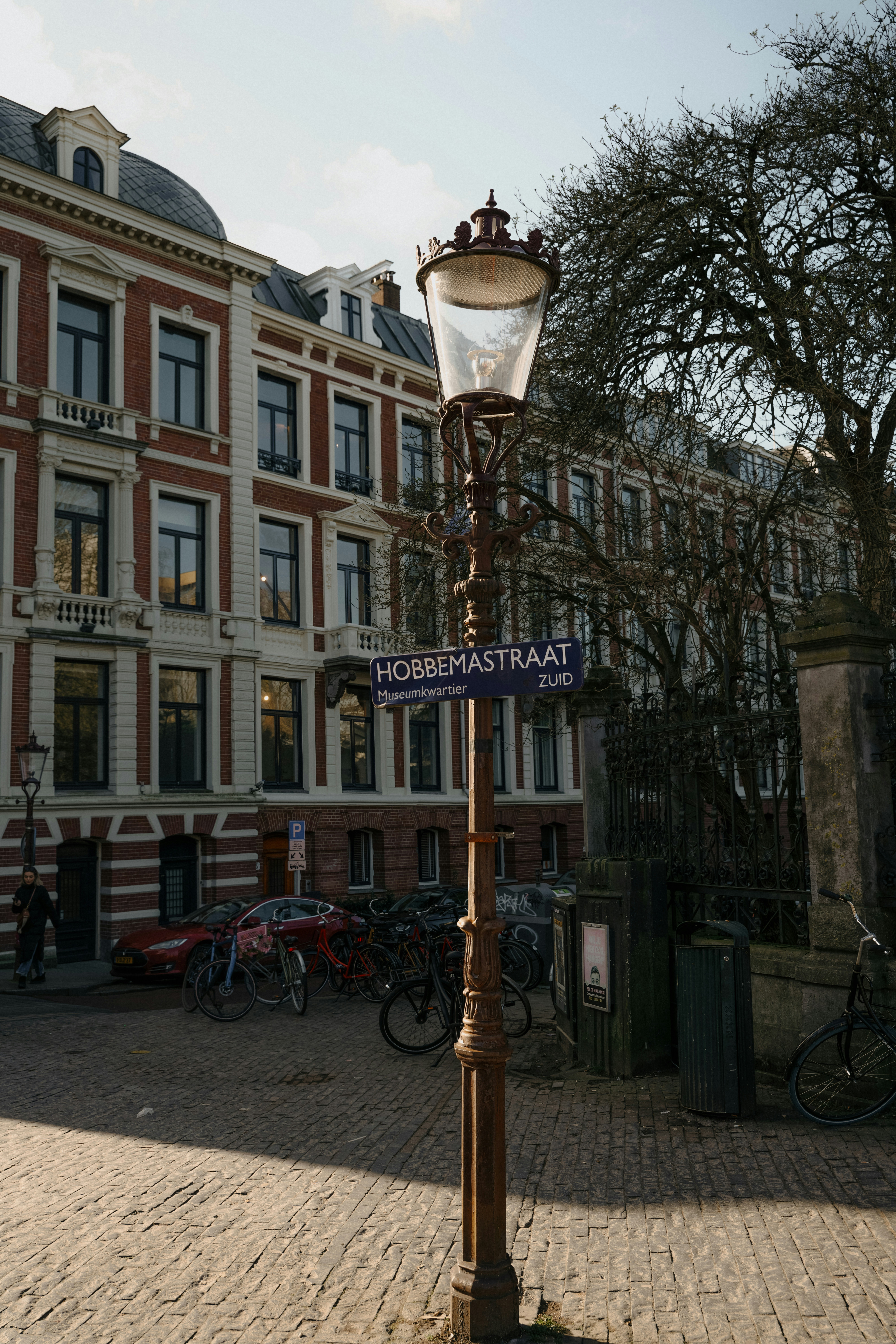 Hobbemastraat Zuid: Cobblestone Corner Framed by a Vintage Lamp and Brick Facades