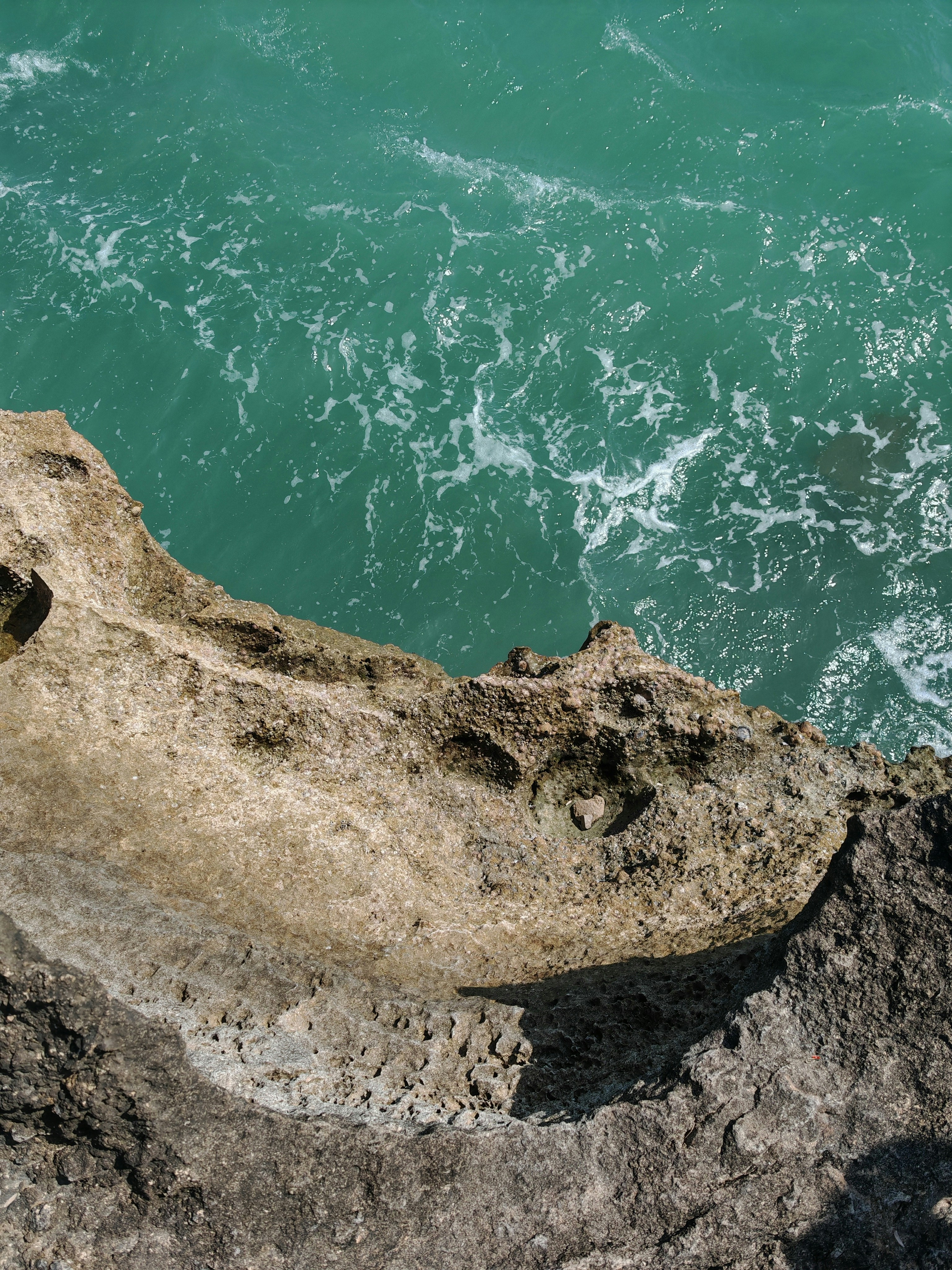 Rocky cliffside meets the beautiful turquoise ocean. photo – Free ...