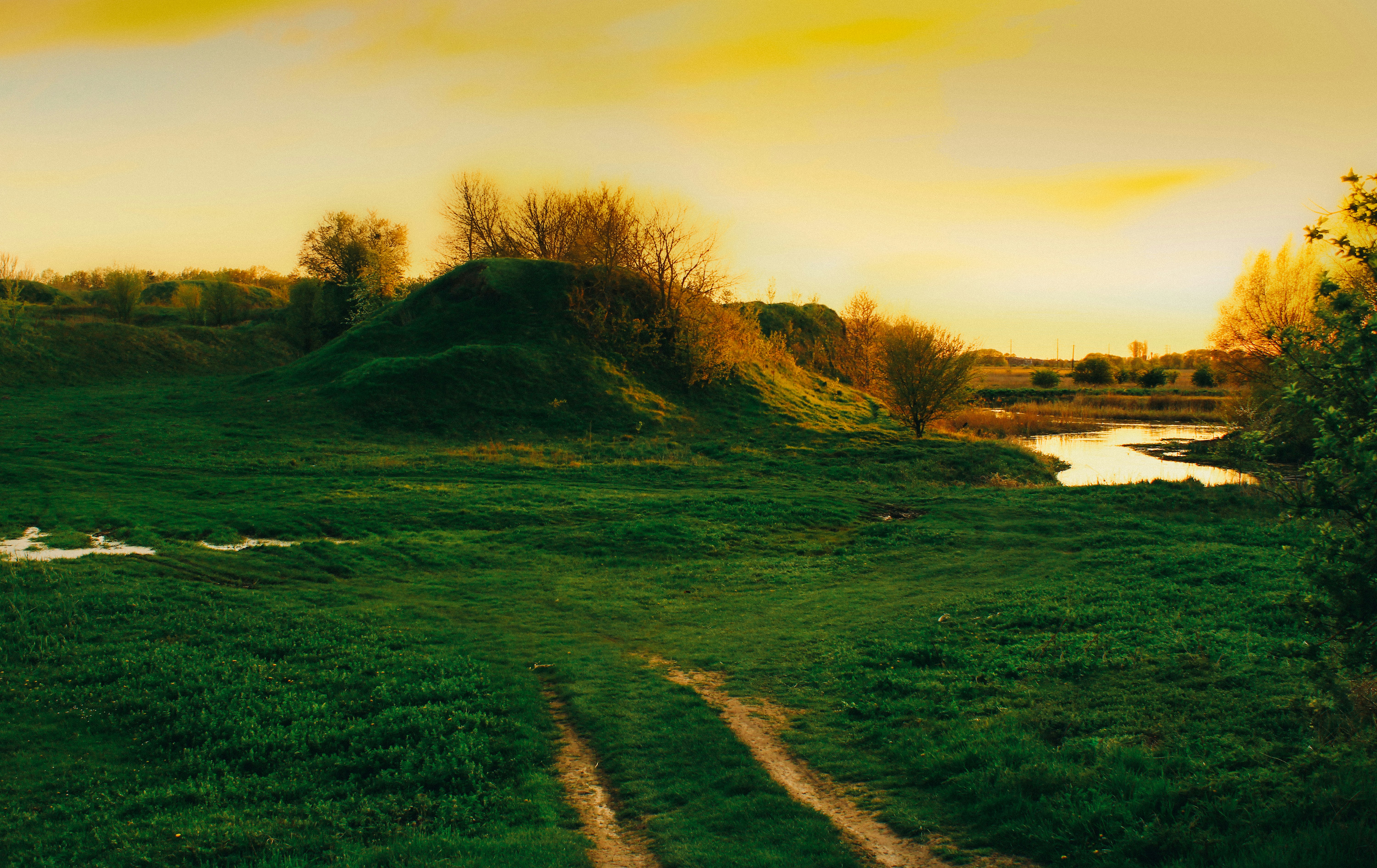Amber Horizon Over a Quiet Creek and Hill