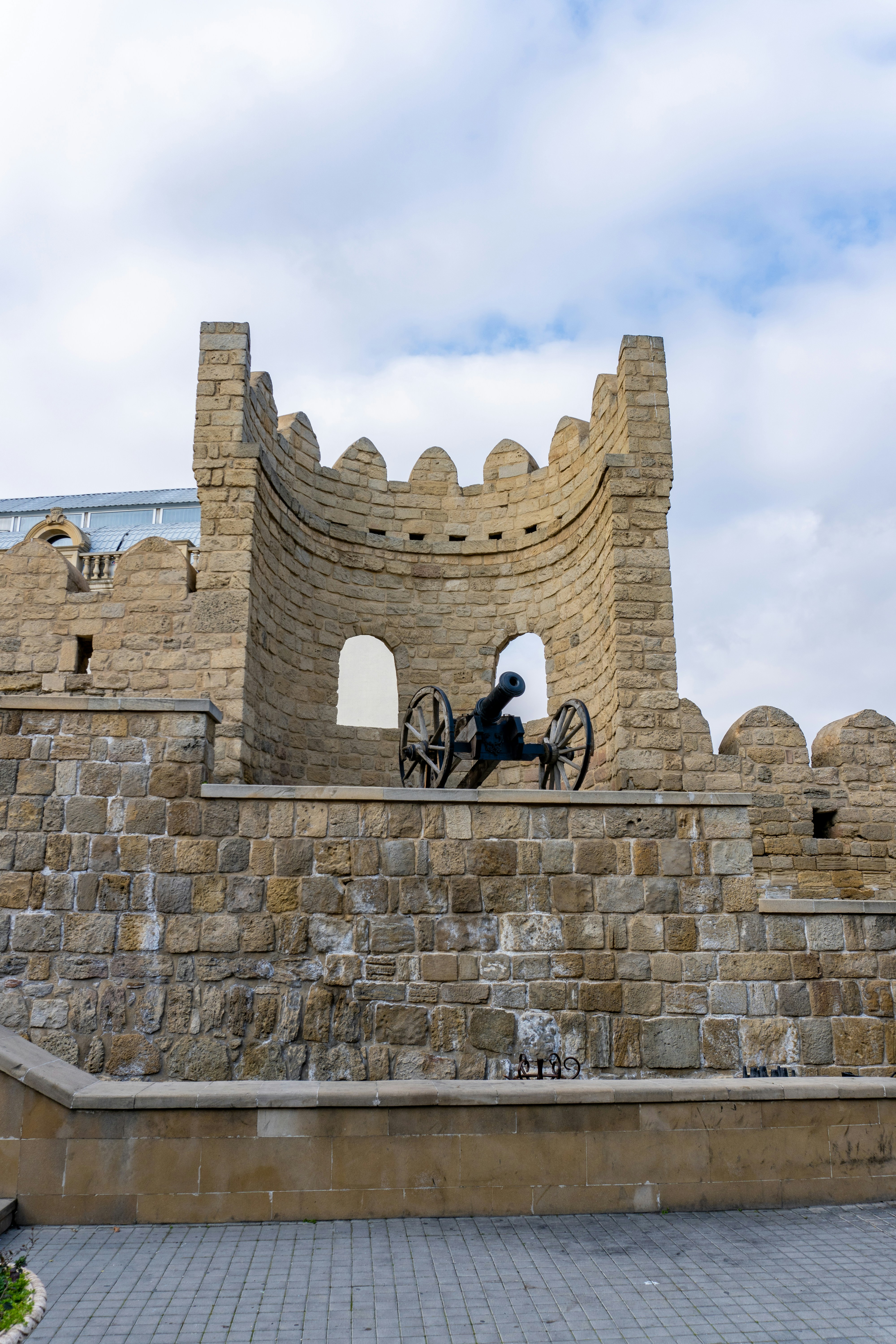 Cannon Over the Bastion: Weathered Stone and Arched Openings Under a Blue Sky