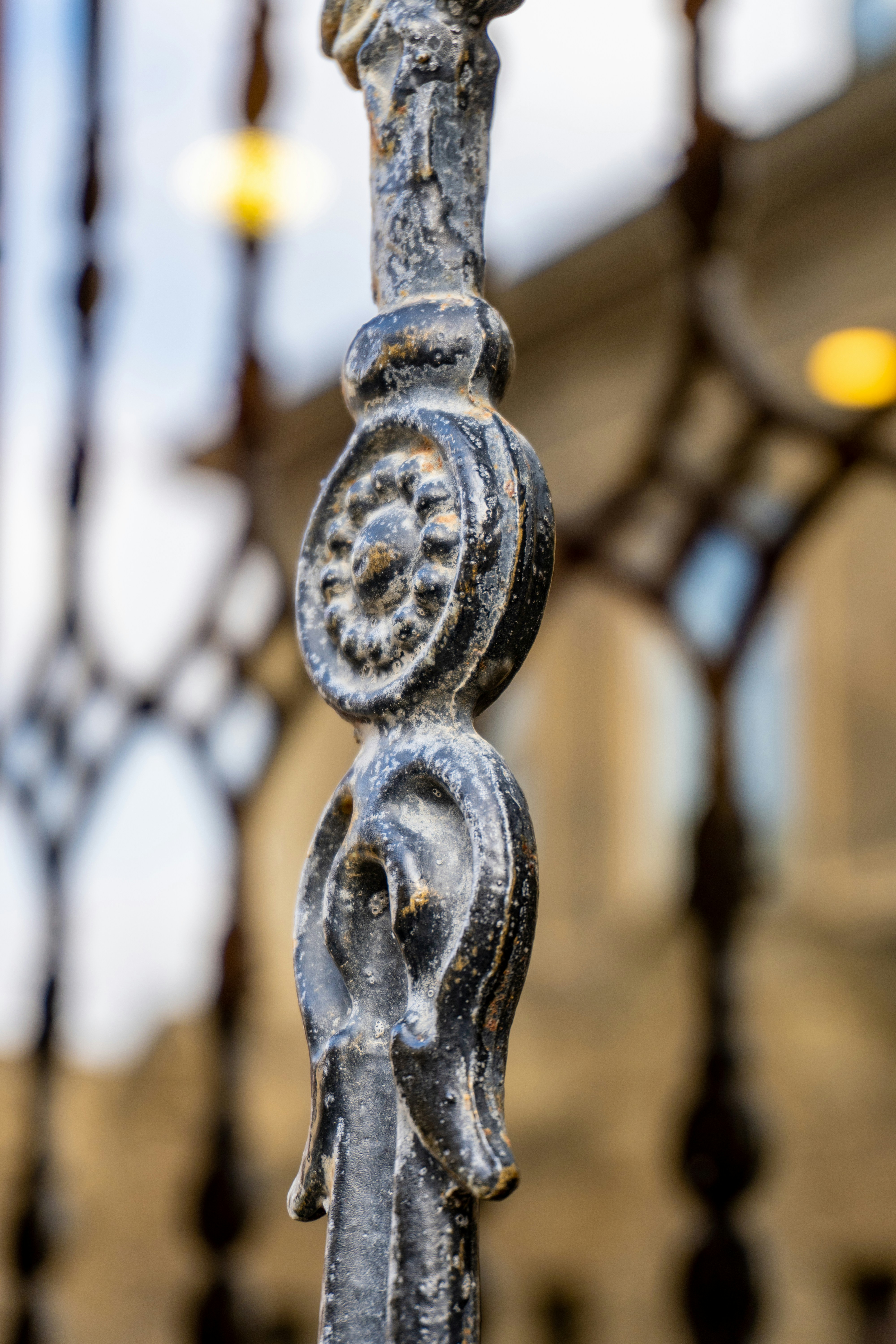 Weathered Iron Rosette in Focus Amid a Blurred Arcade