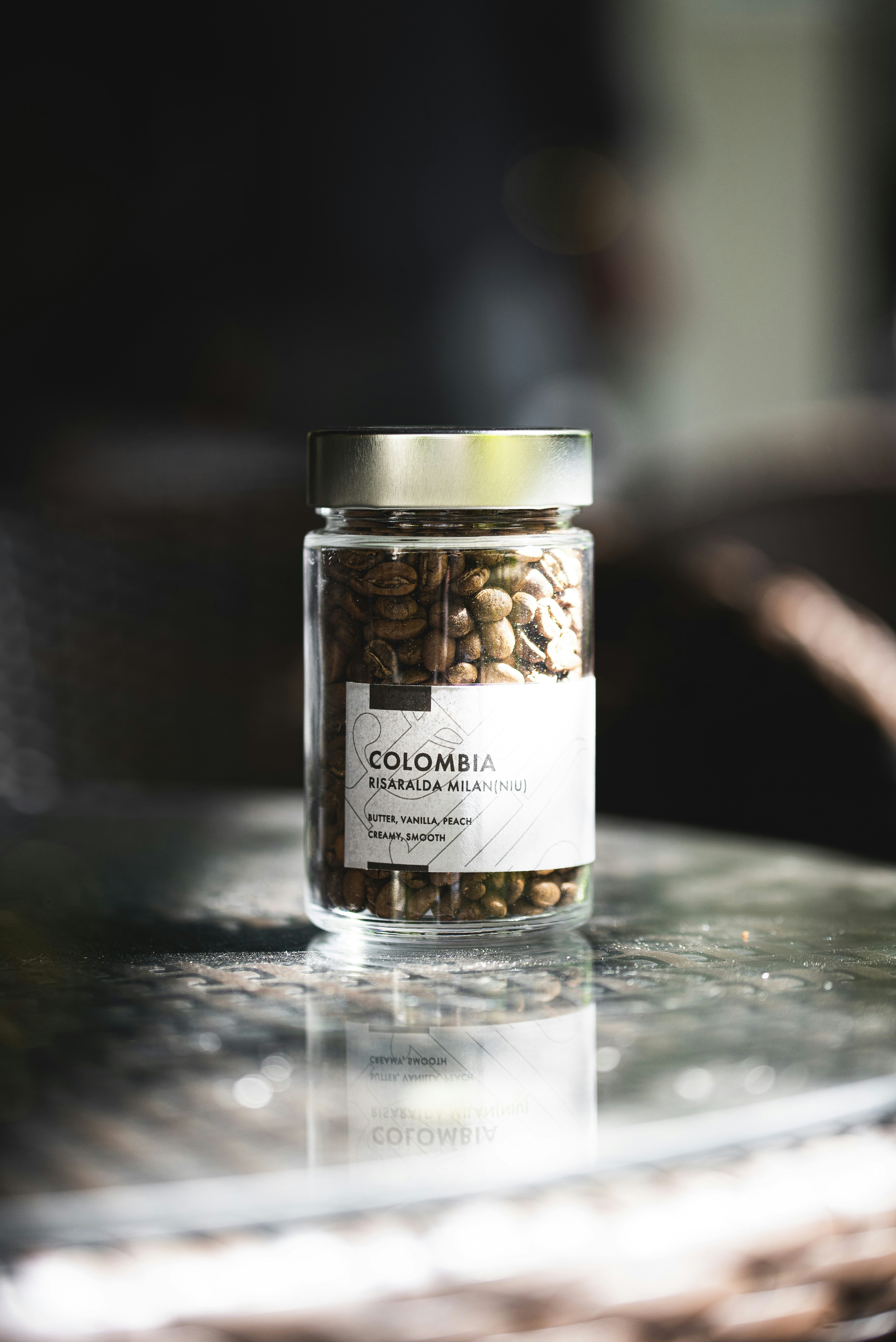 Hidden Roast: A Tiny Jar of Colombia on a Glass Table