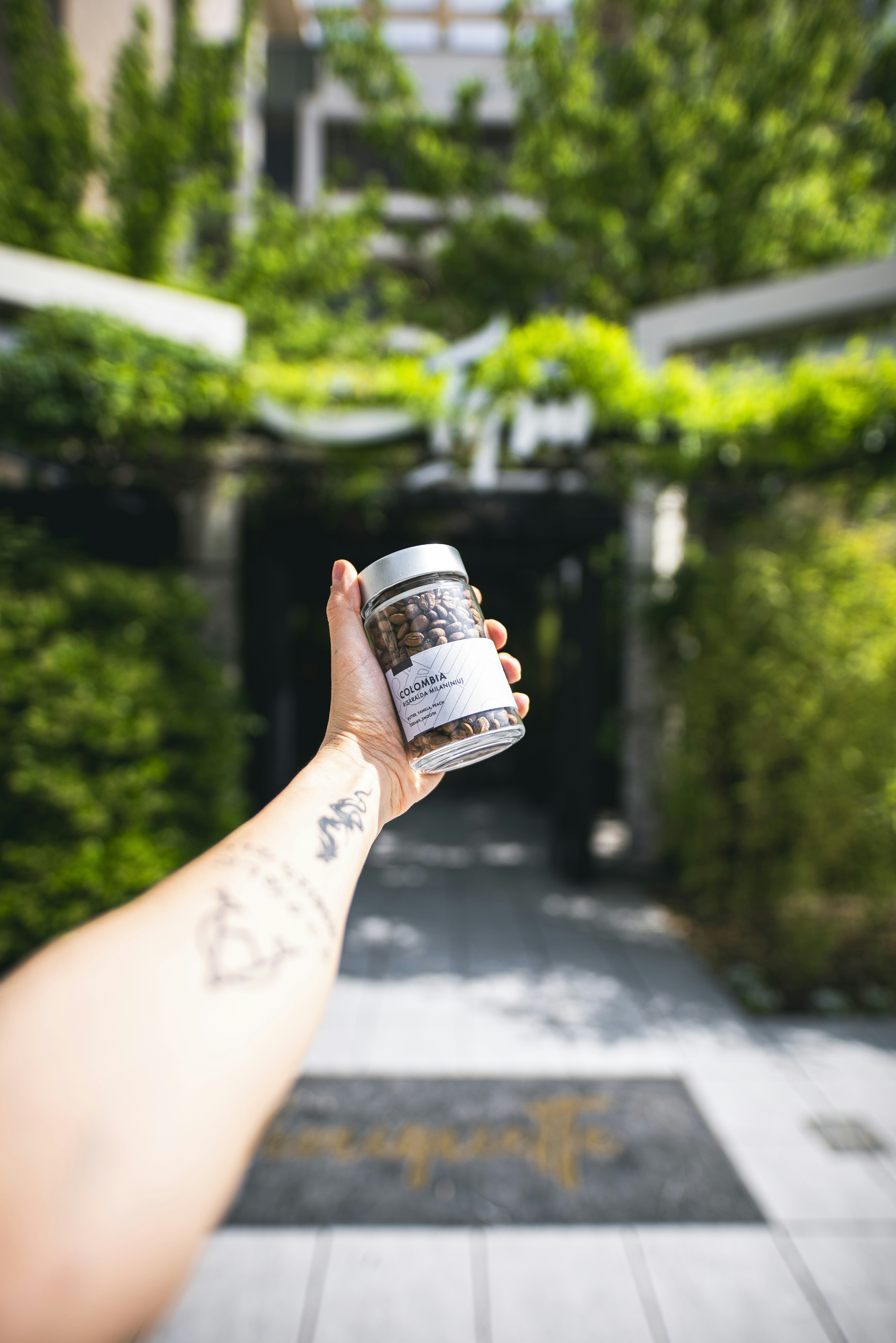 Handheld Focus: A Coffee Can Gripped Against a Lush Courtyard Blur
