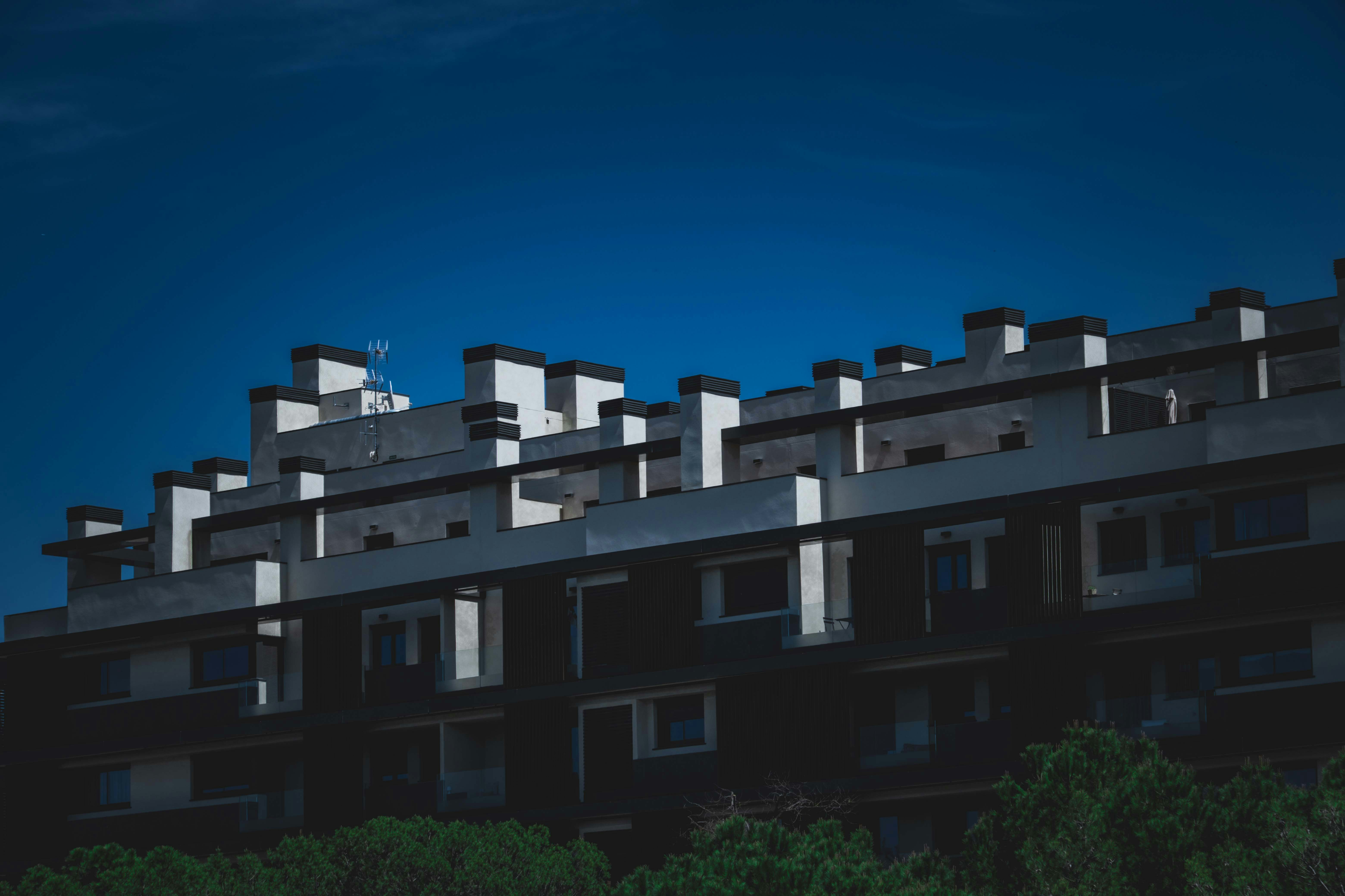 Blue Hour Brutalism: White Vertical Accents Crown the Rooftop
