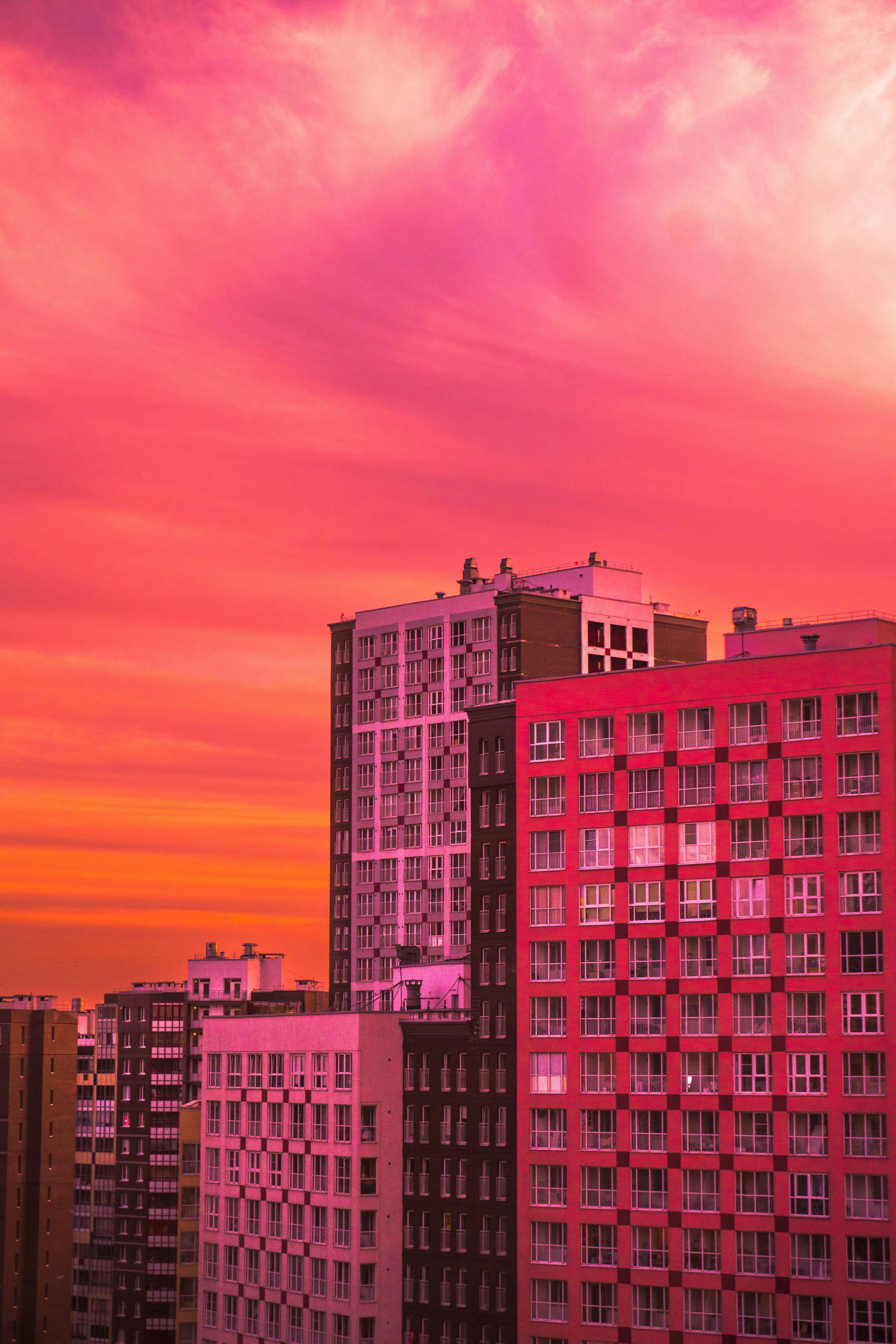 Crimson Dusk Drapes a Skyline of Brick Towers