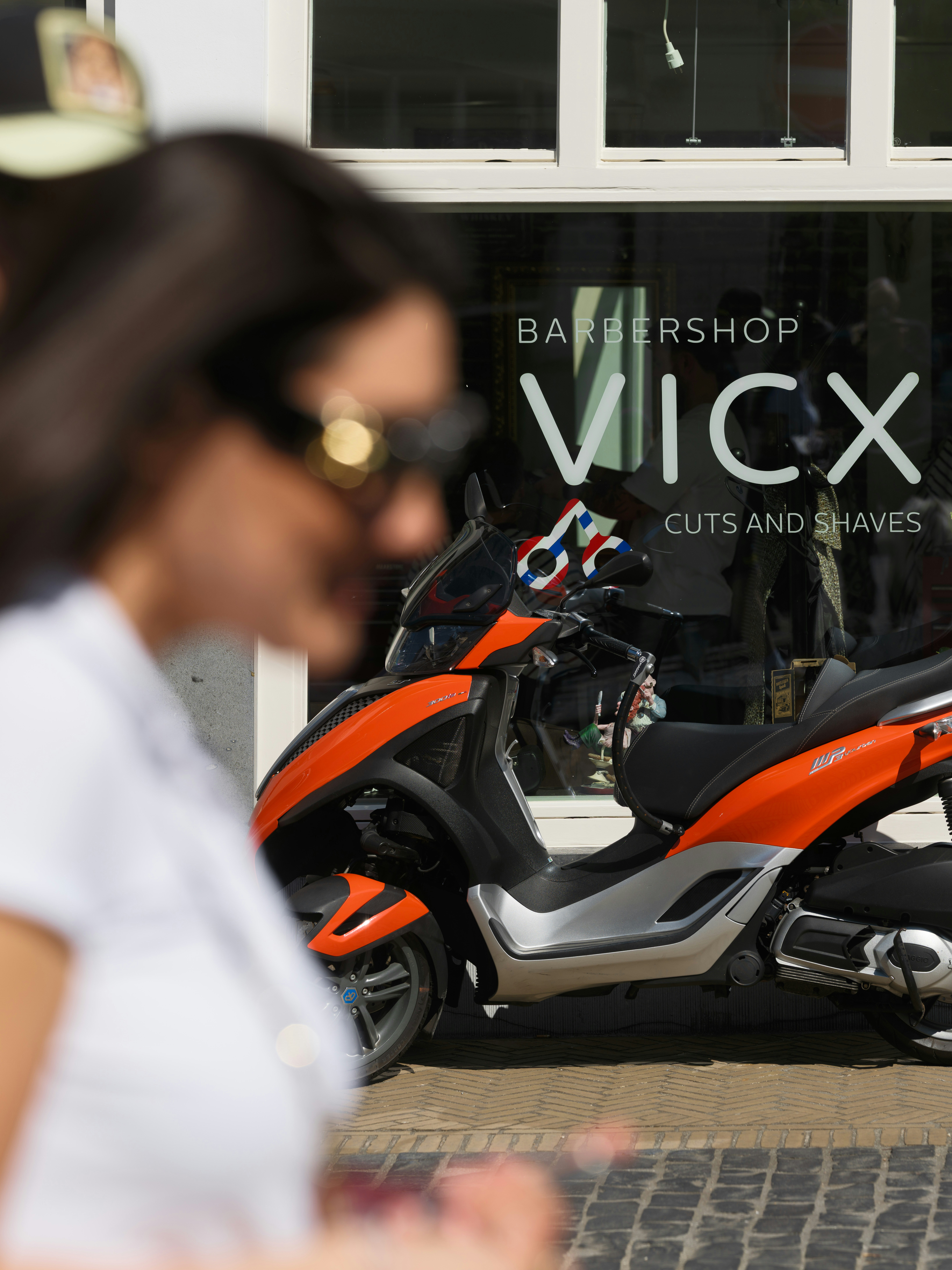 Orange Motorcycles in the Window: A Barber Shop Scene