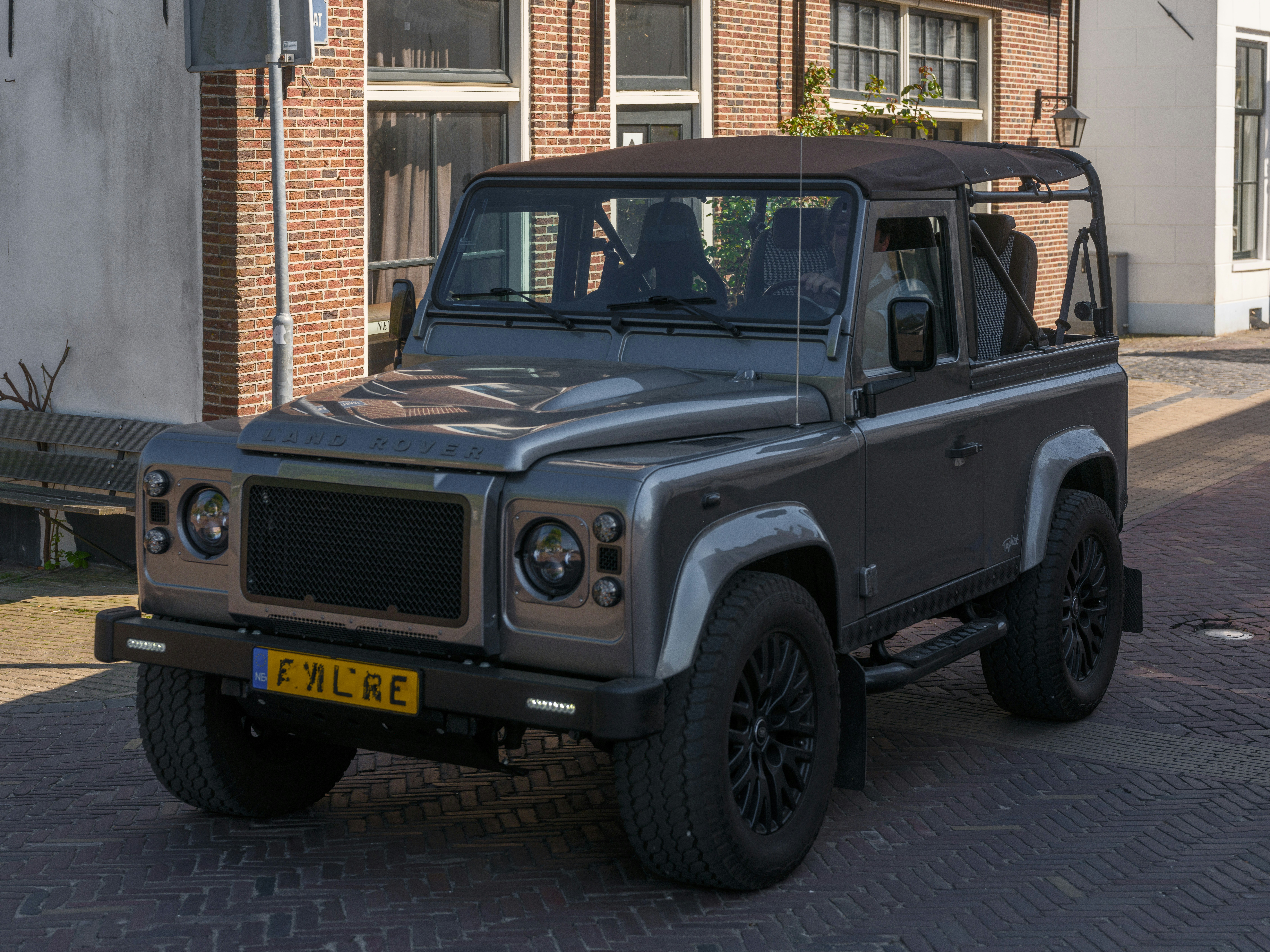 Urban Rugged: Defender Pauses Along a Brick Street