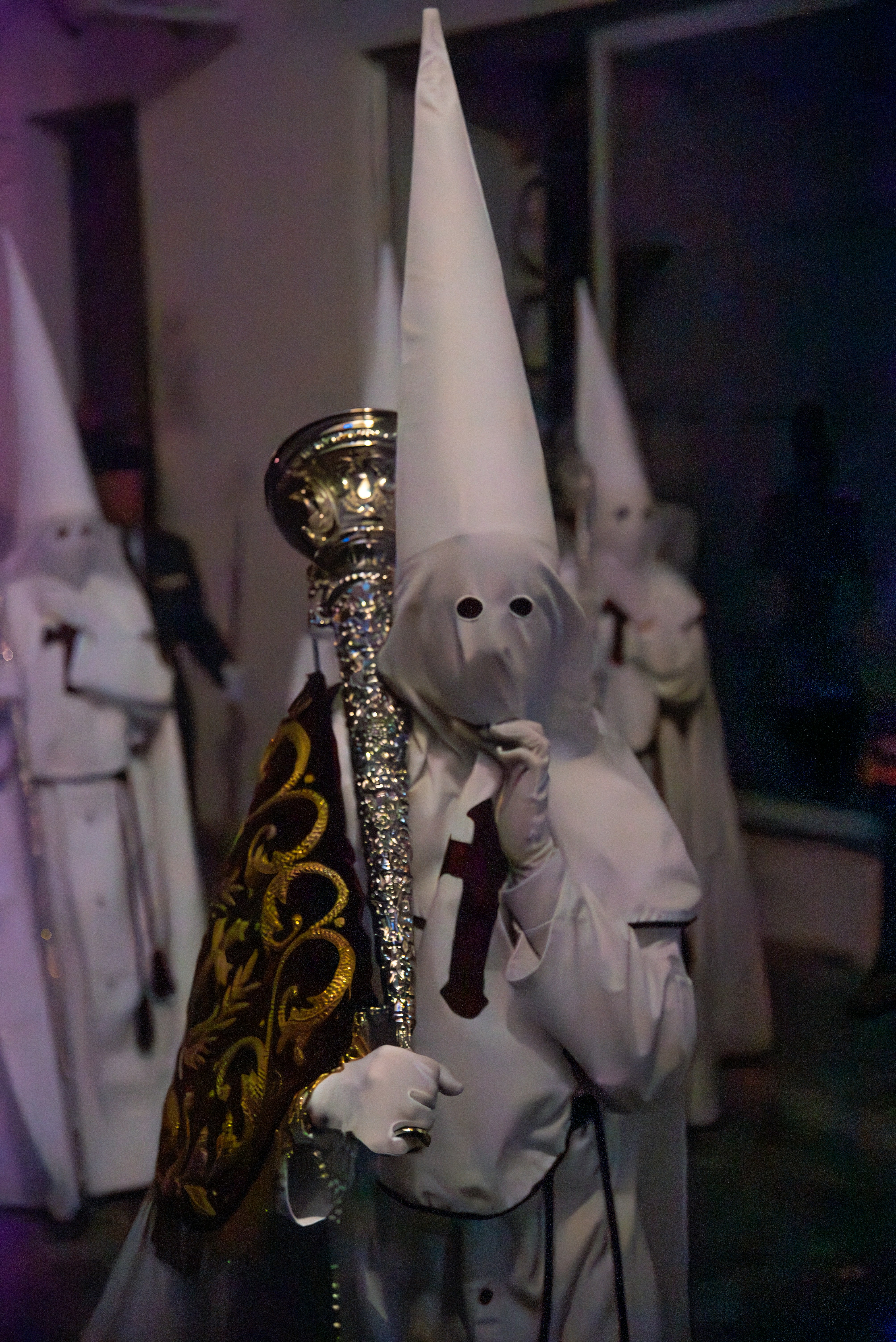 People in white hoods are marching in a procession. photo – Free Night ...