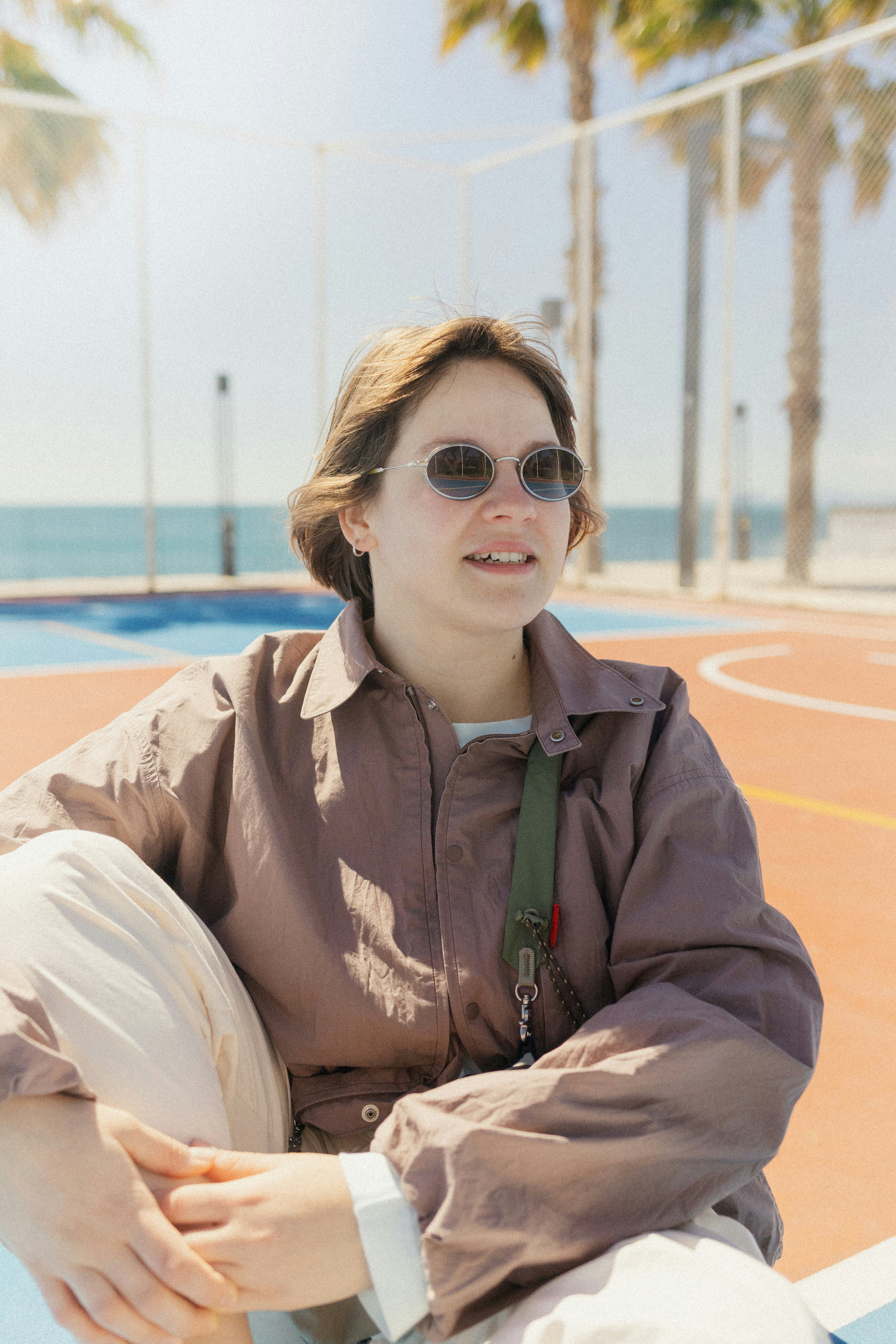 Sunlit Portrait on a Beachside Court with Palm Trees and Ocean in View