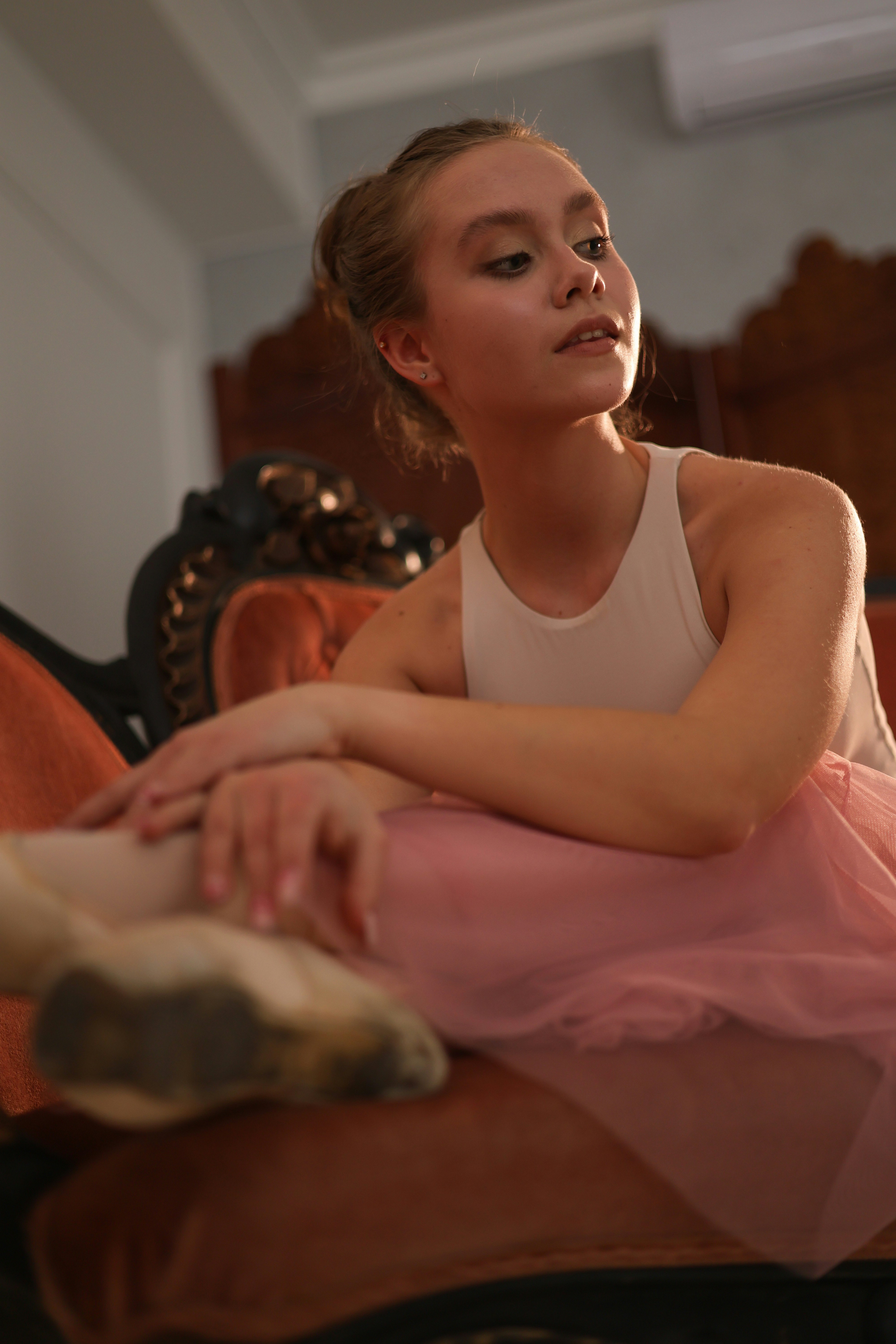 Intimate Poise in Dim Light: Ballet Student Resting on Velvet