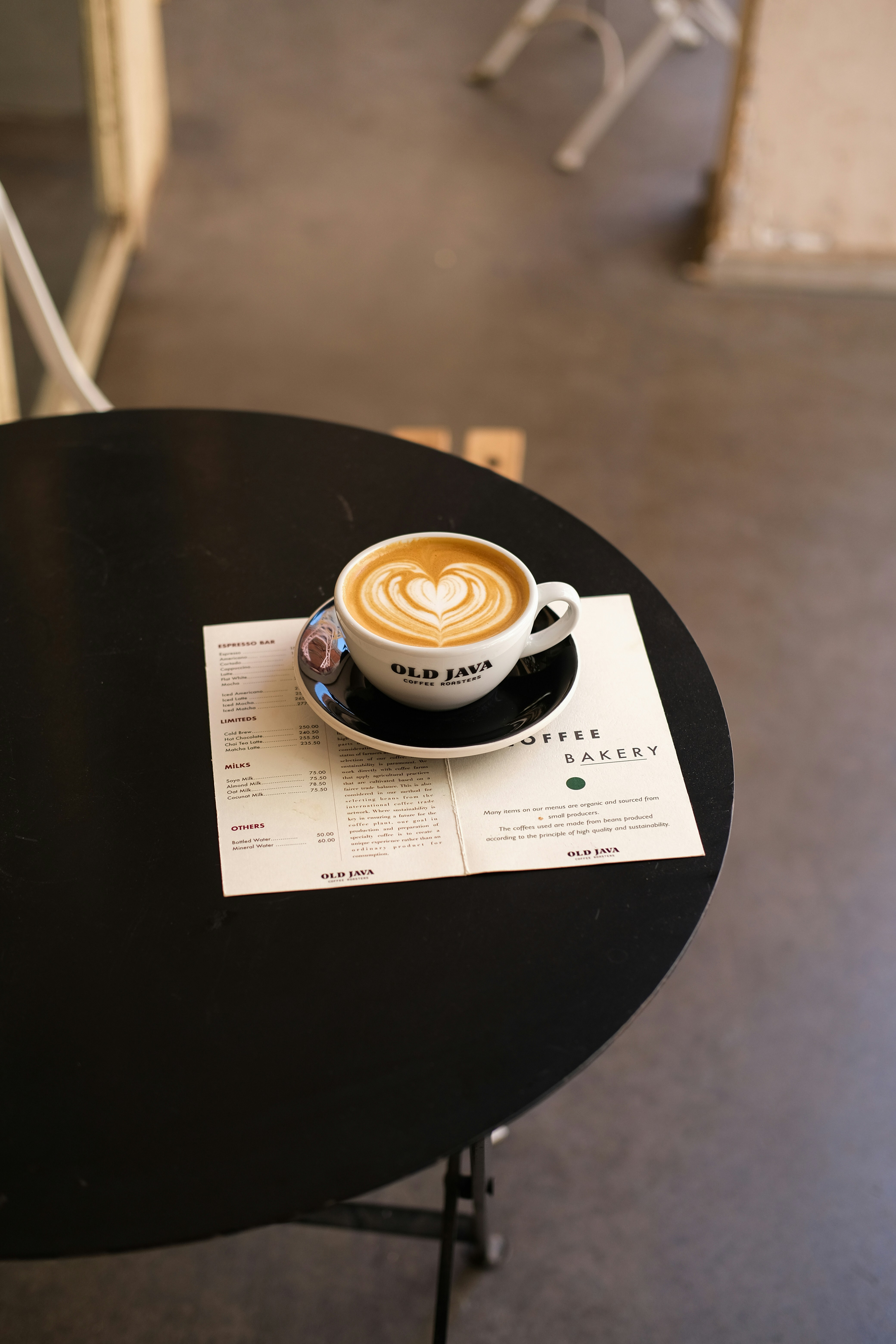 El arte latte se encuentra encima de un menú en una mesa negra. foto ...