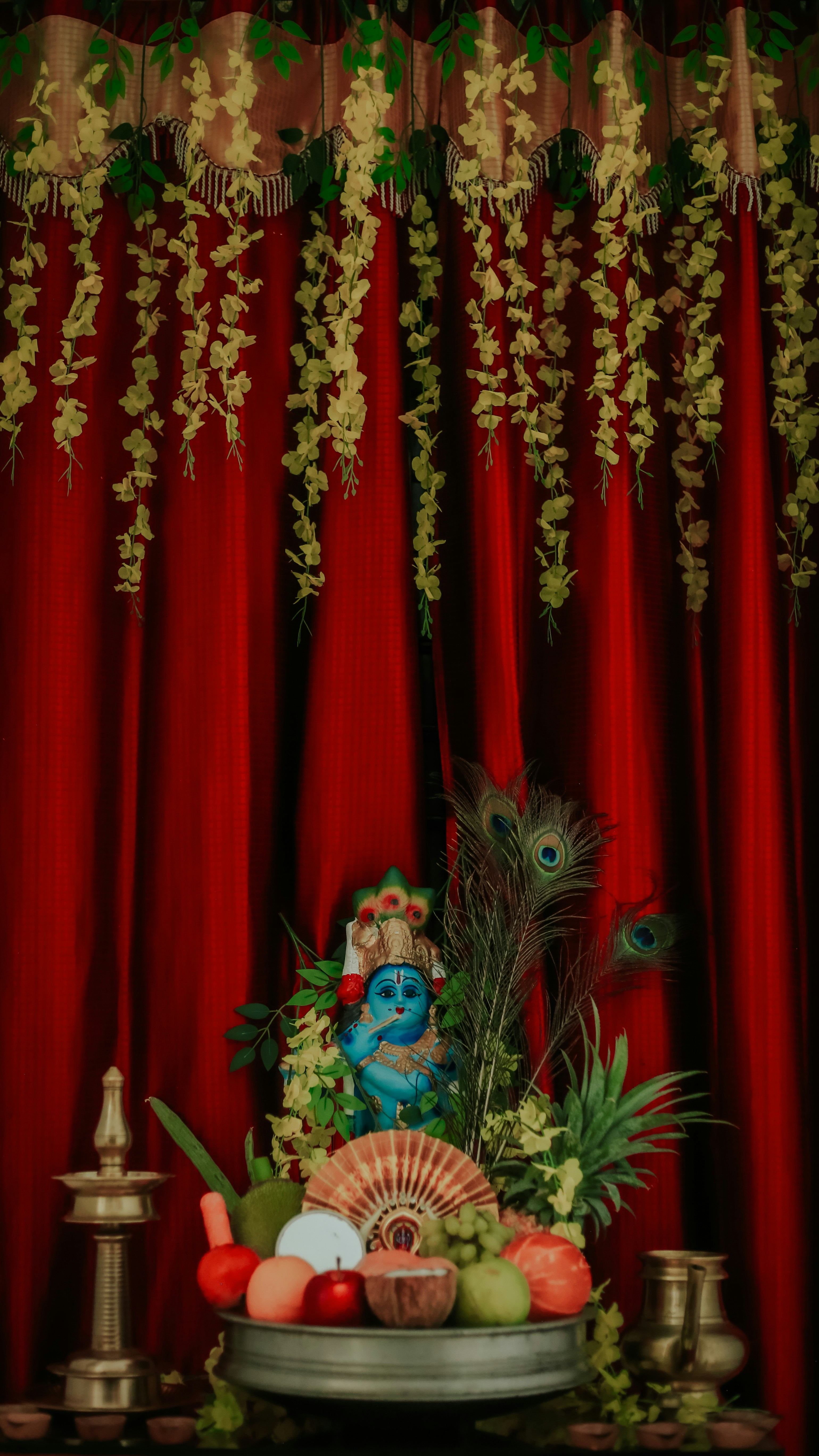 An altar with a statue, fruit, and peacock feathers. photo – Free ...