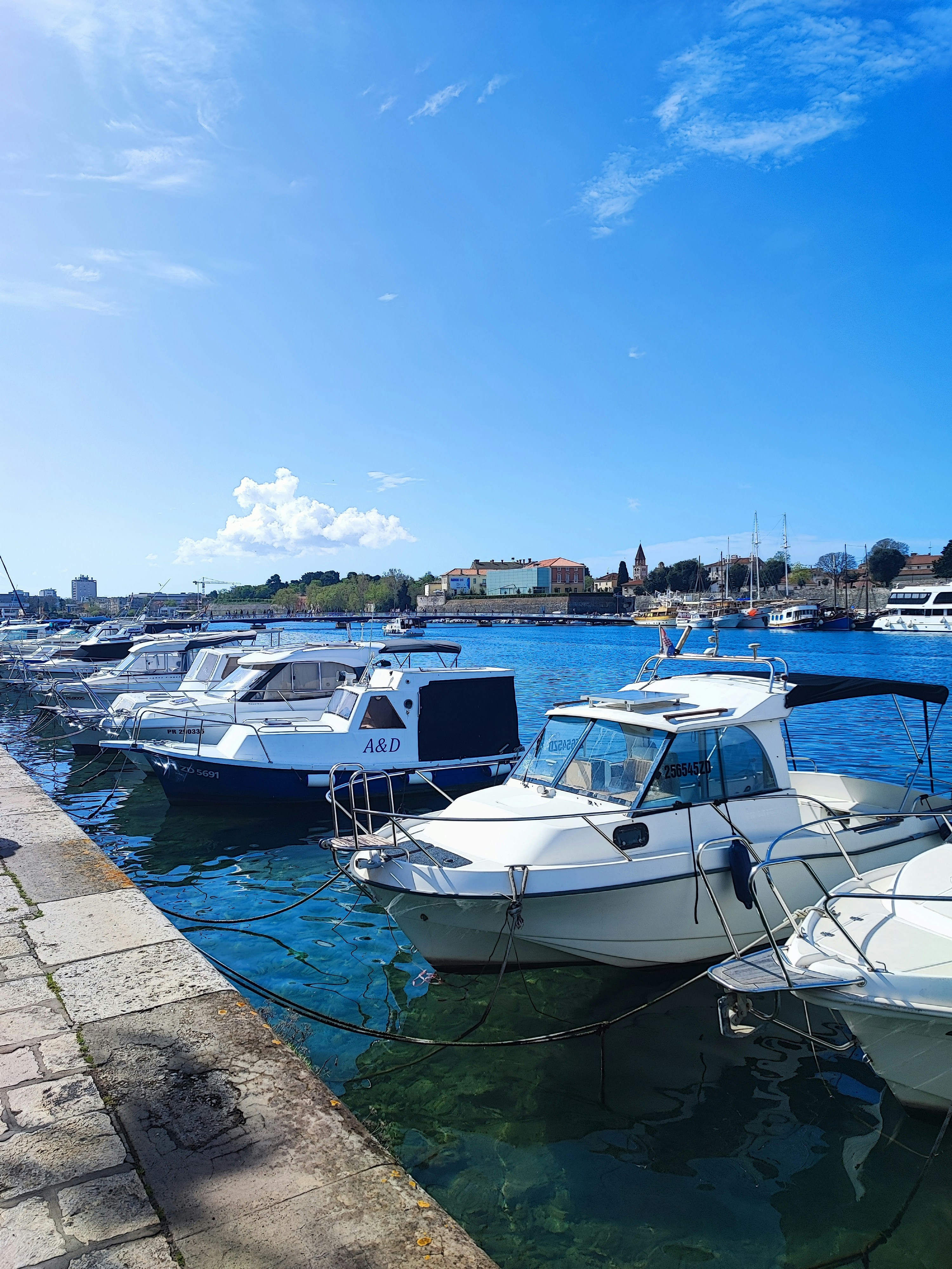 Harbor Ballet: Boats Rest Along a Sunlit Promenade