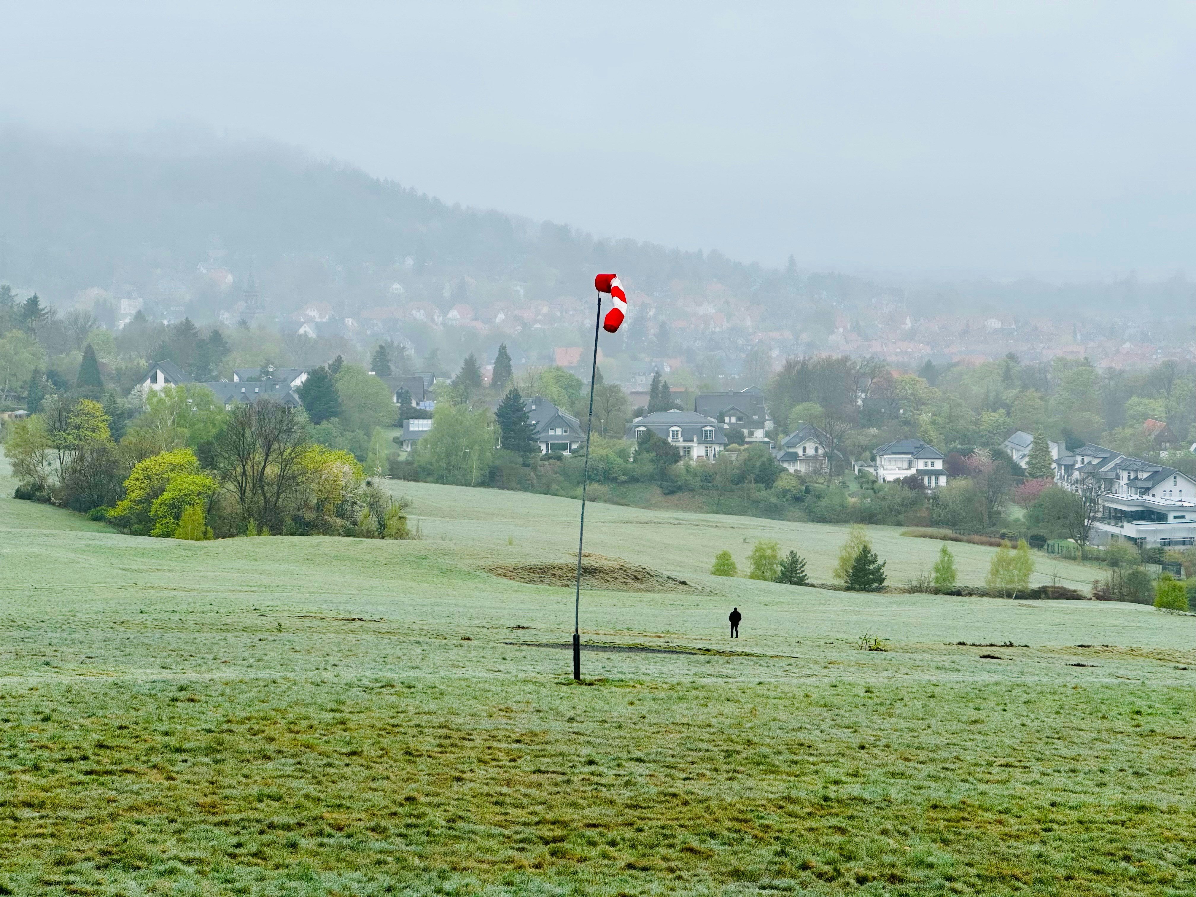 Windsock Beacon Over a Misty Valley Field