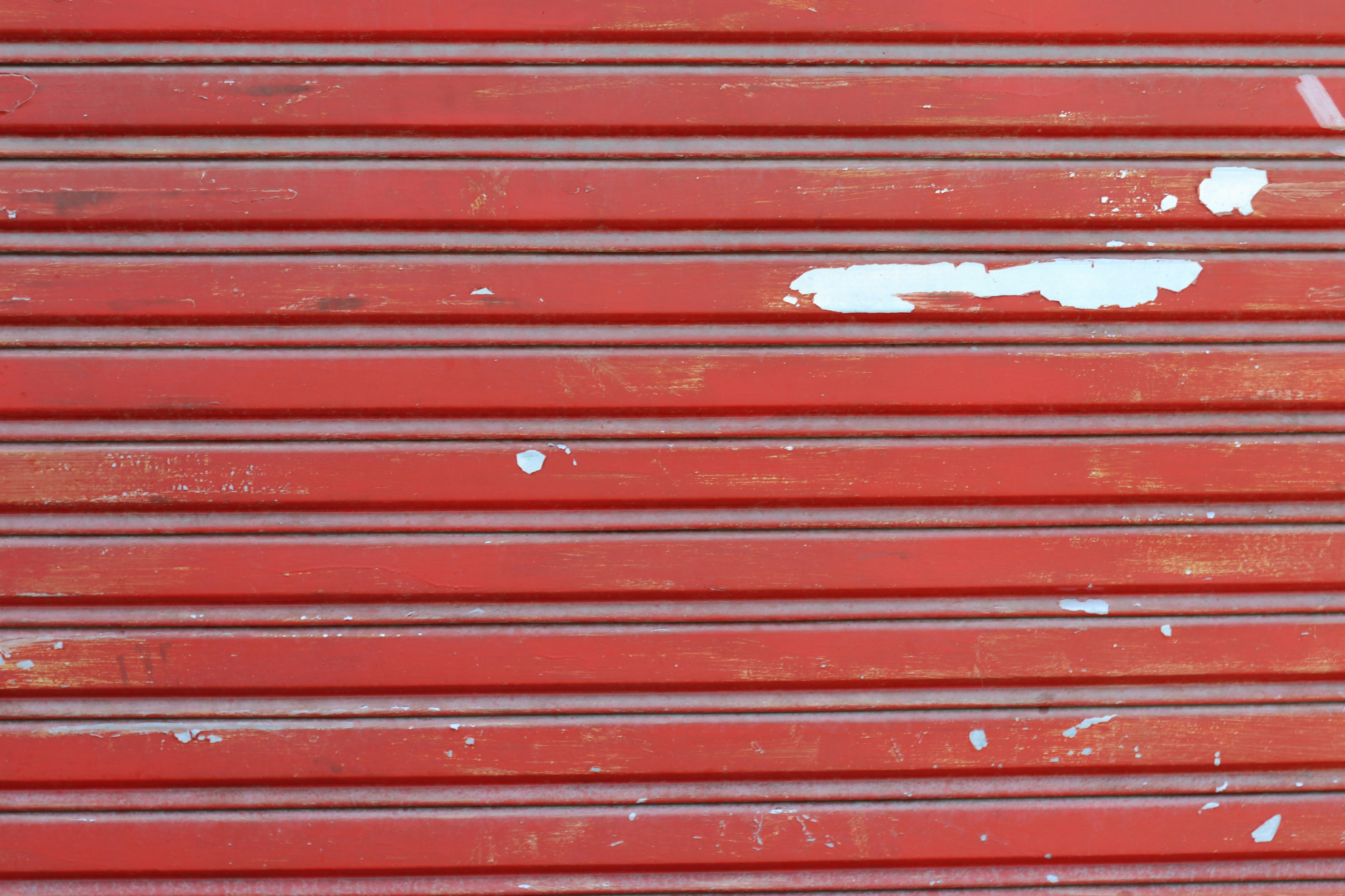 El obturador de metal rojo y desgastado muestra signos de desgaste ...