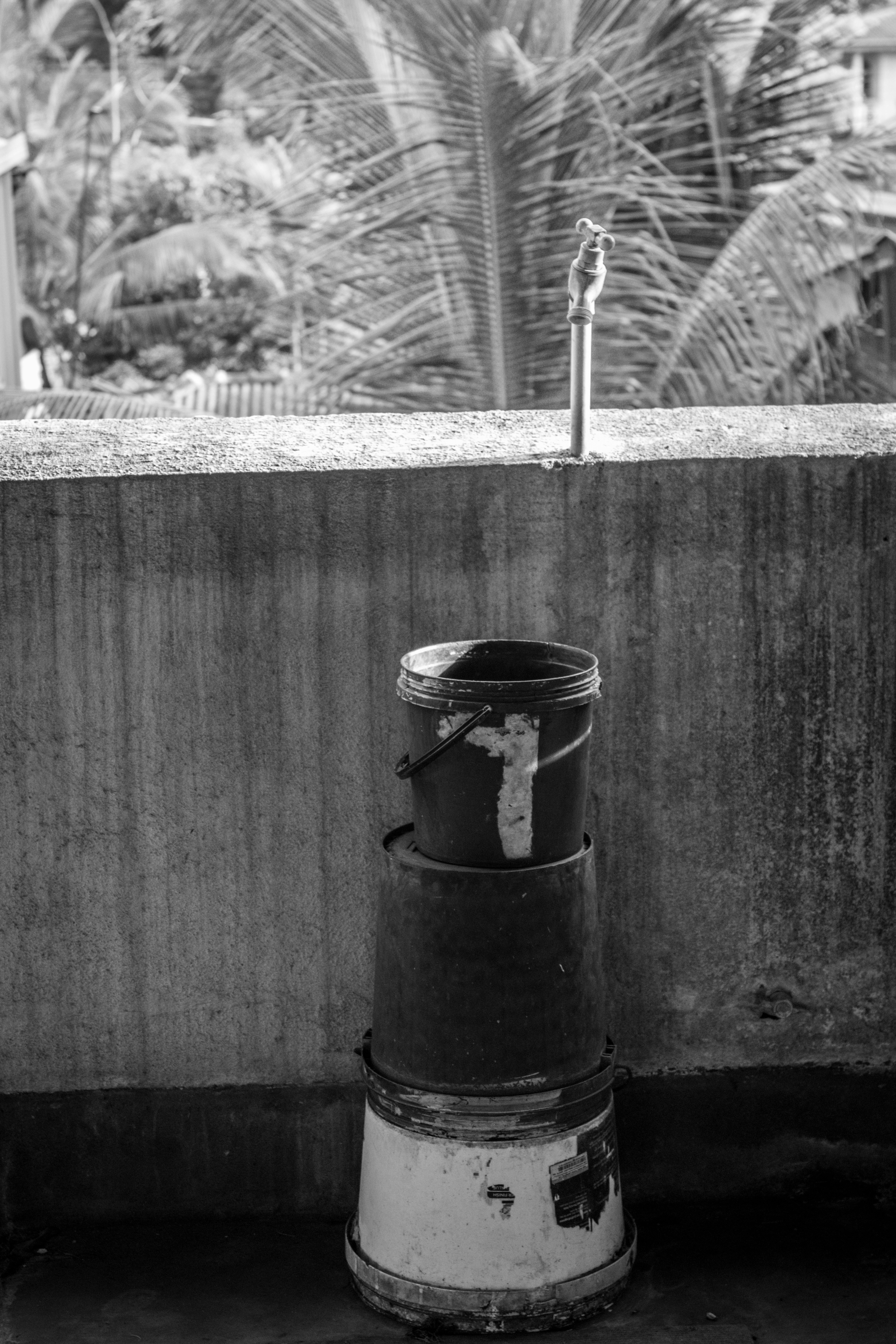 Stacked buckets under a faucet in black and white. photo – Free Drink ...