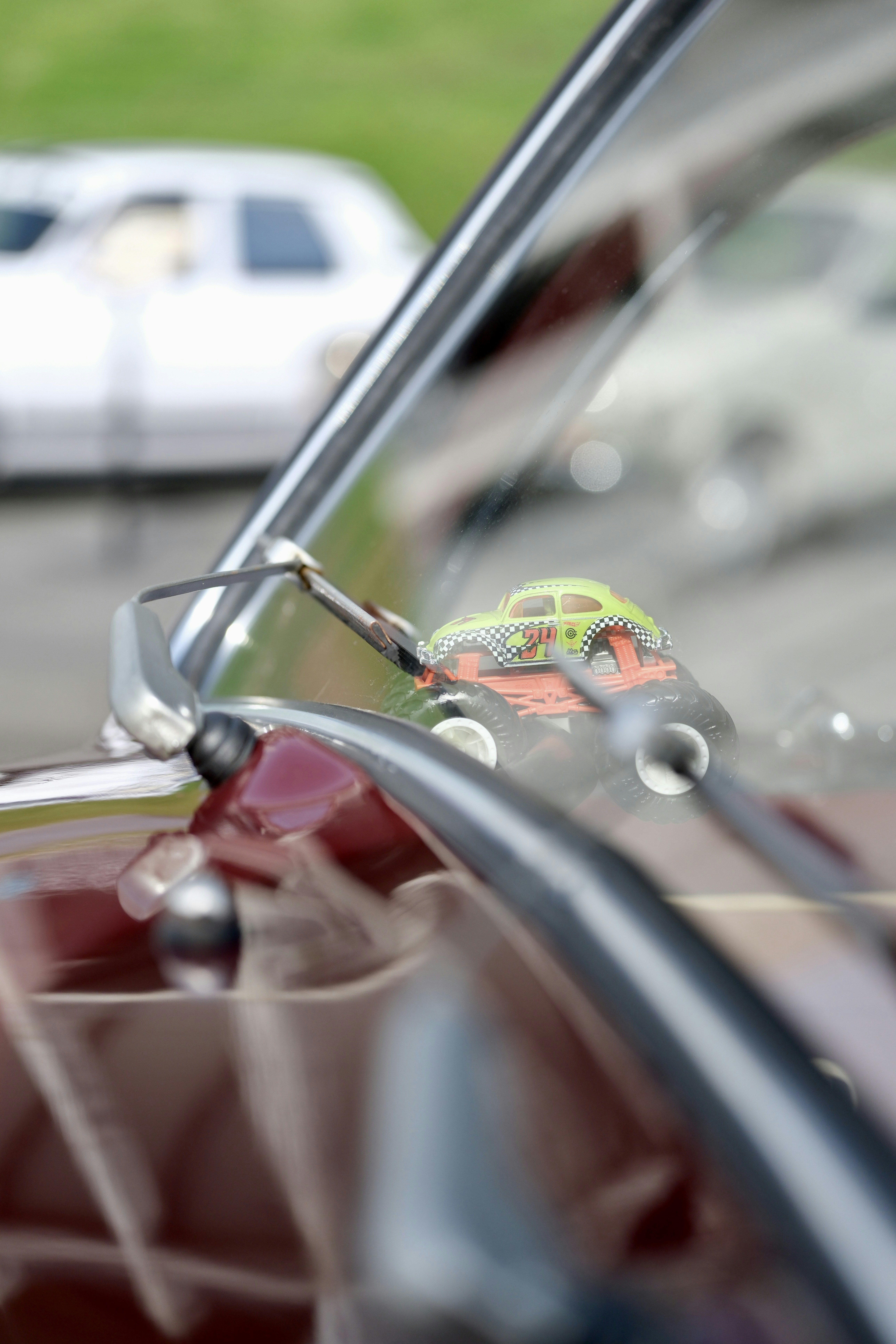 Toy Car on the Dash: Tiny Racer Reflected in a Classic Car Window