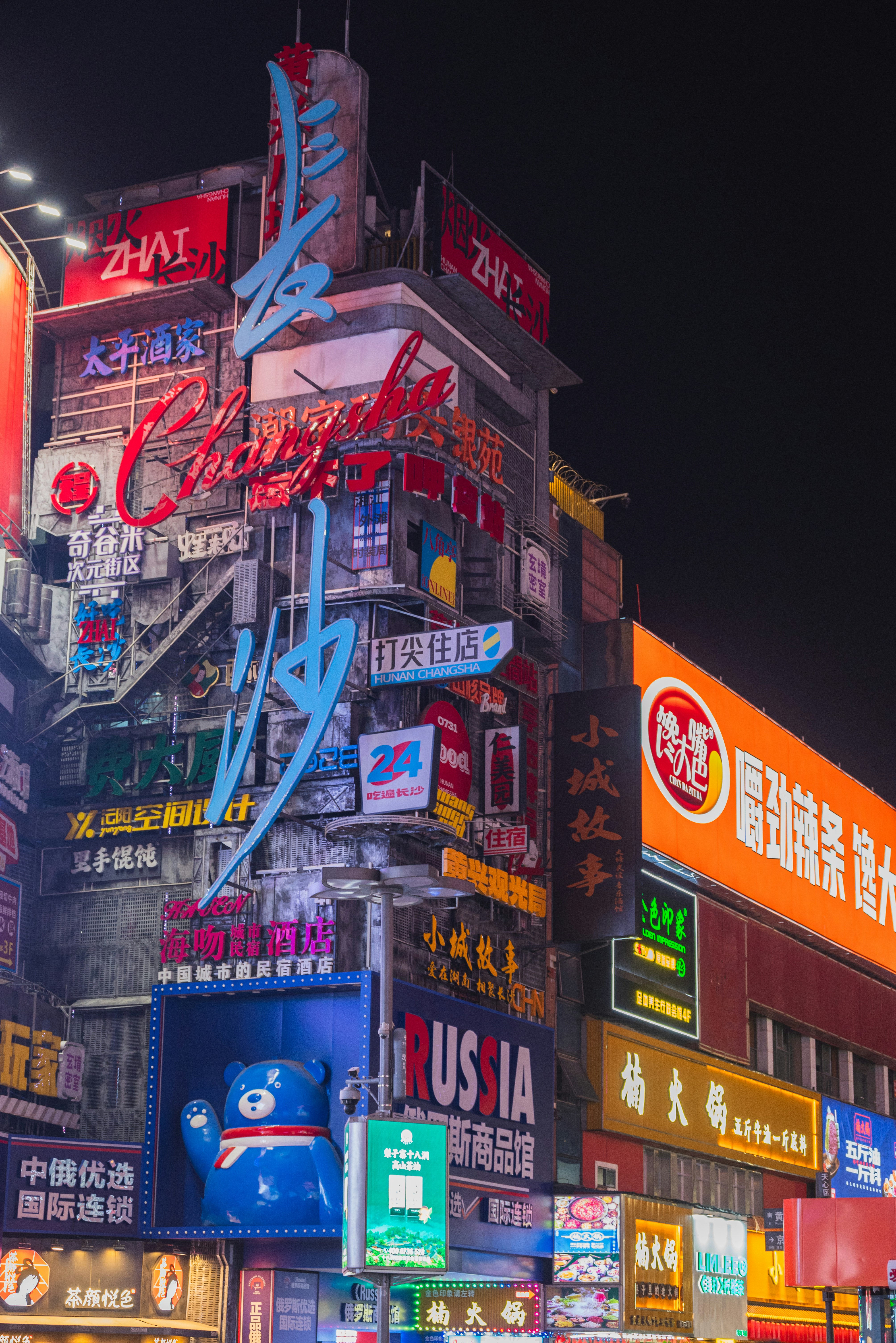 Neon signs illuminate a building facade at night. photo – Free Building ...