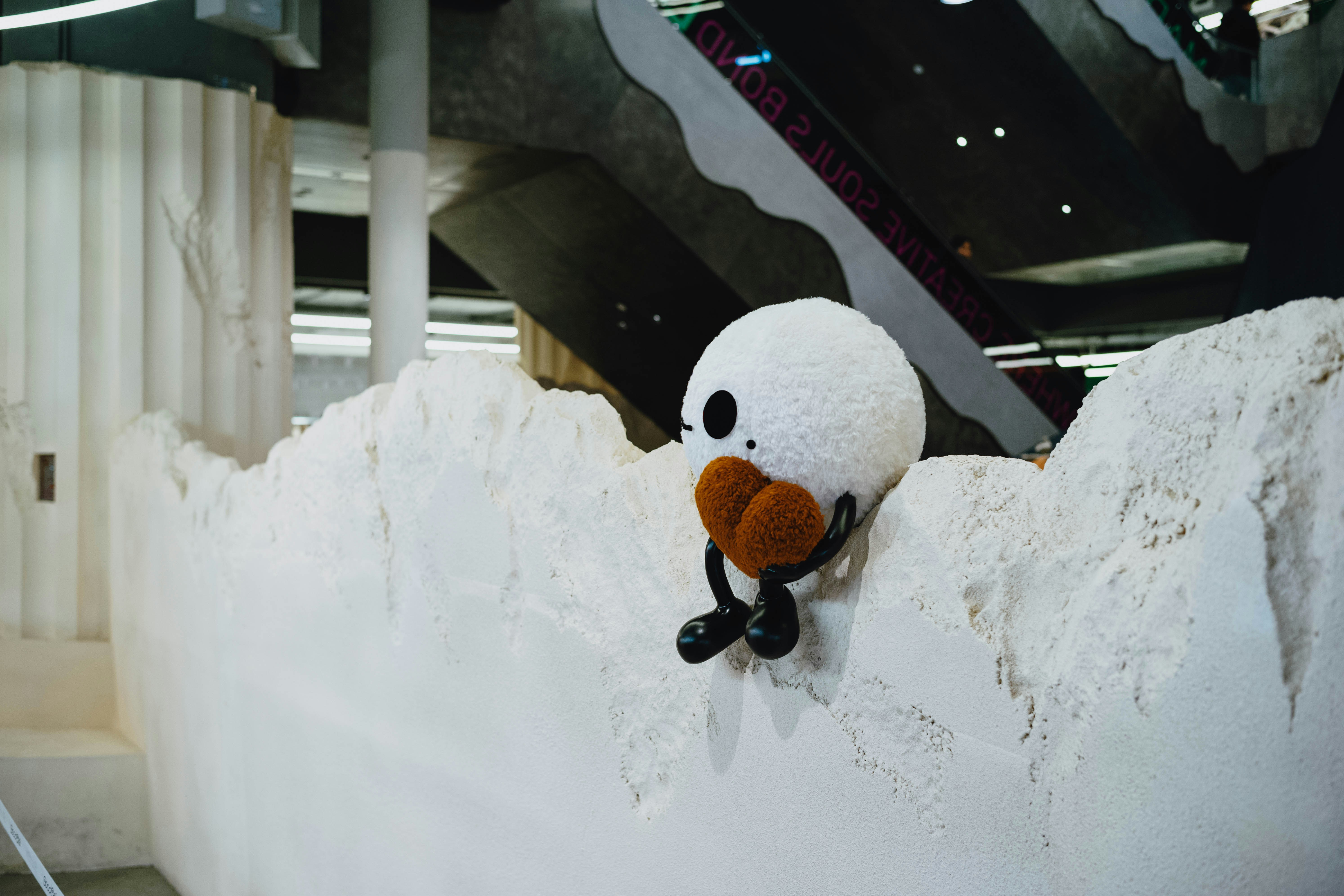 A whimsical creature sits on a white wall. photo – Free Panda Image on ...