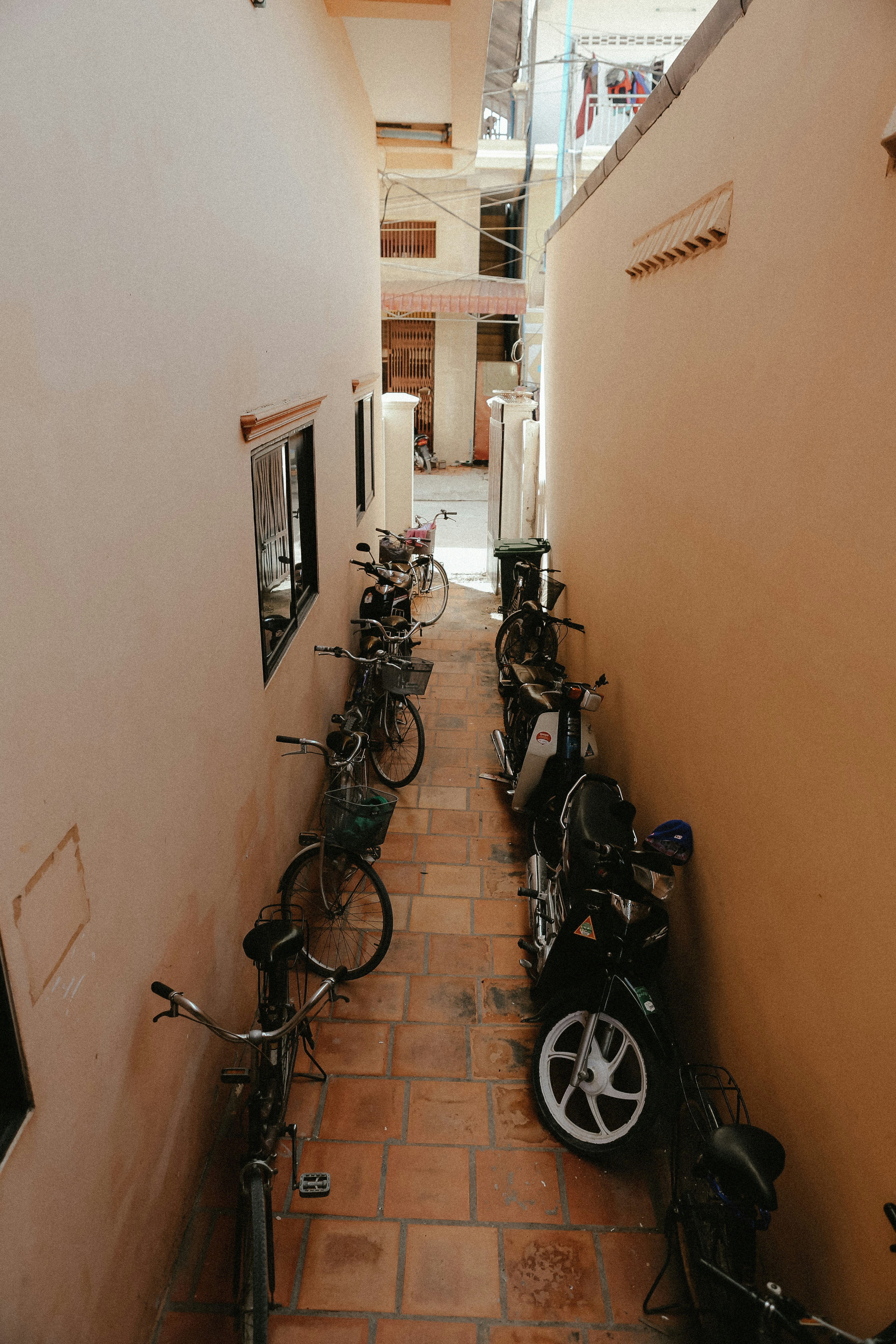 Between Peach Walls: A Quiet Alley of Bicycles