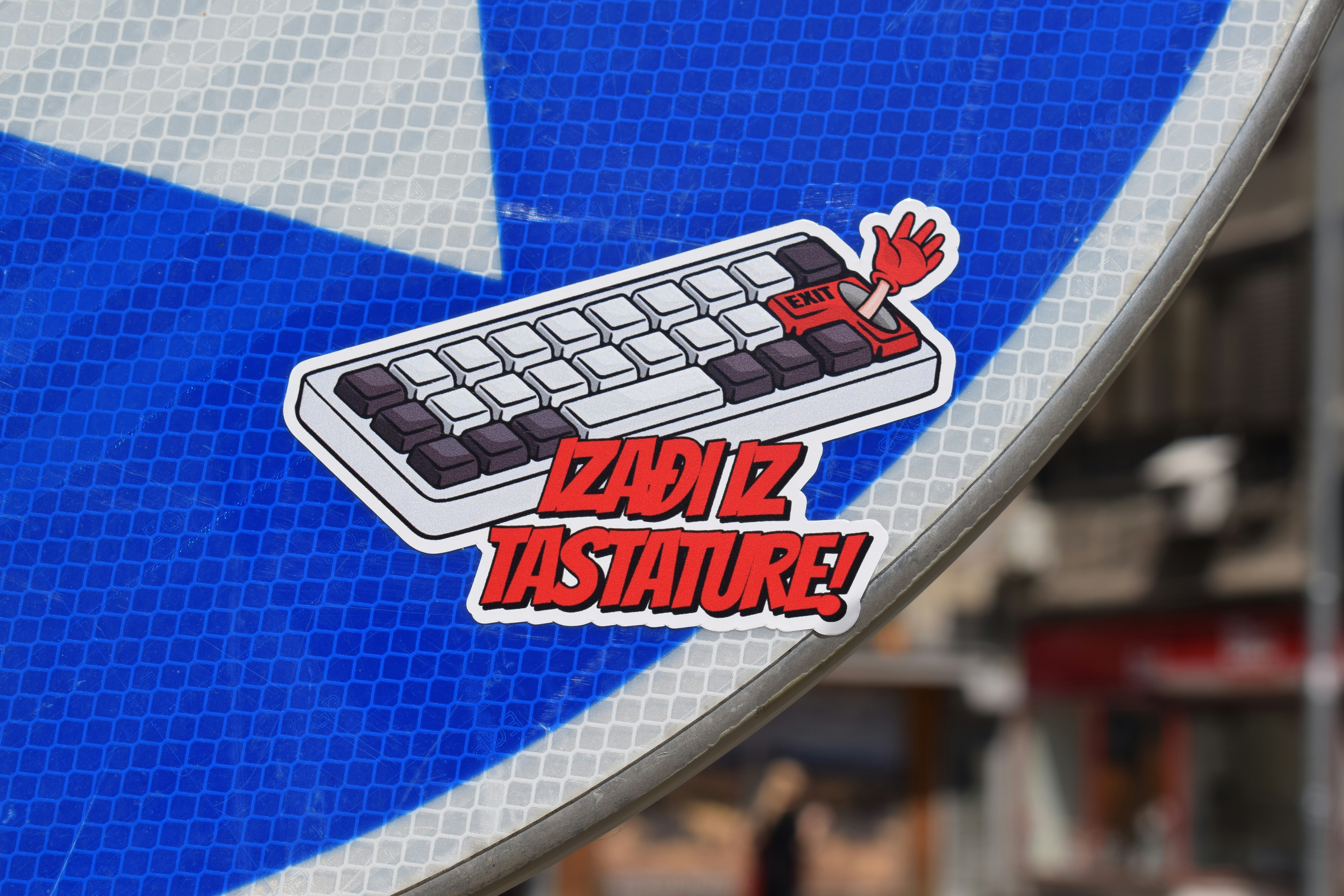 Retro Keyboard Sticker Adorns a Textured Blue Circular Sign