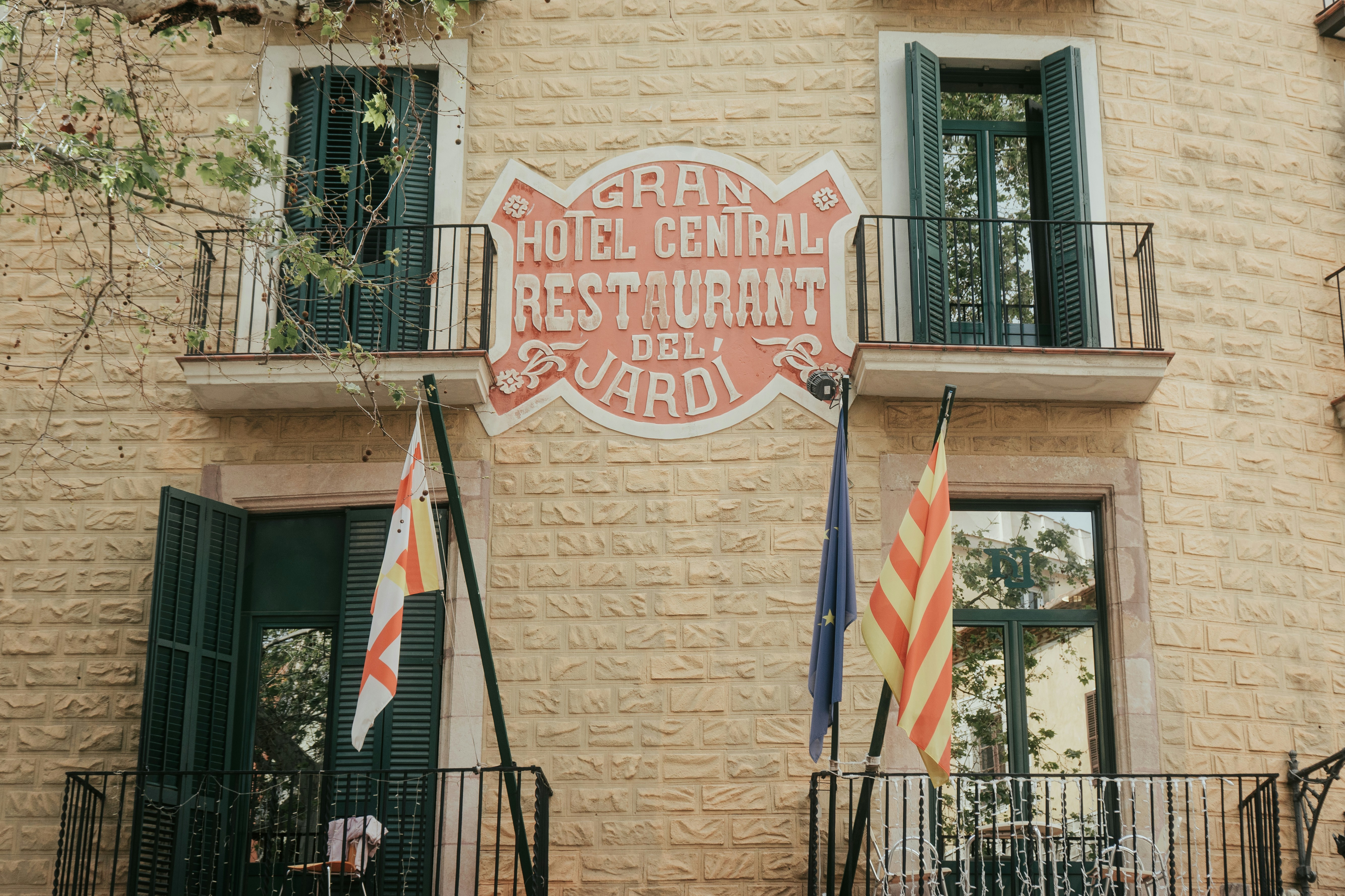 The gran hotel central building features flags and open windows. photo ...