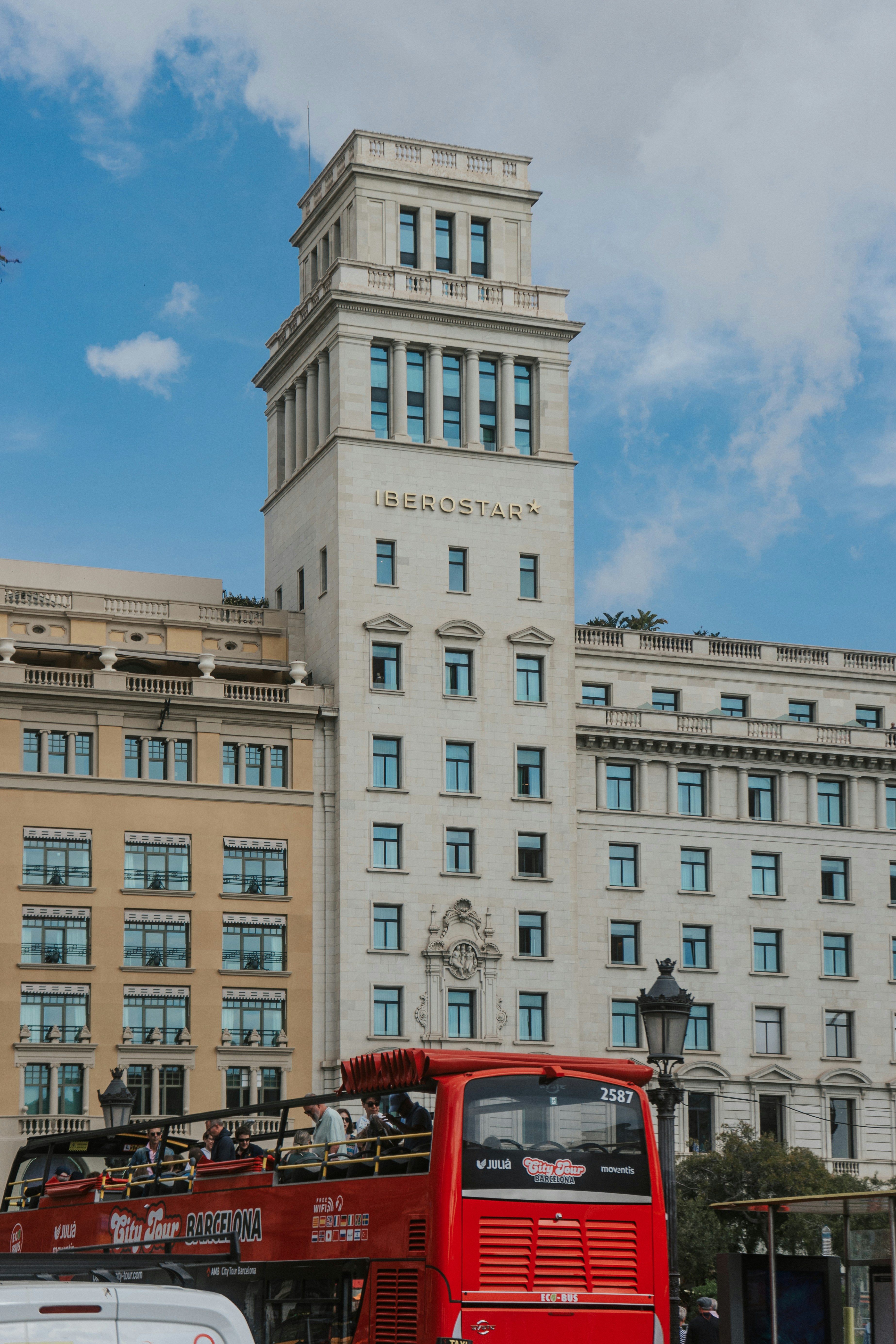 A red tour bus passes a tall building. photo – Free Car Image on Unsplash