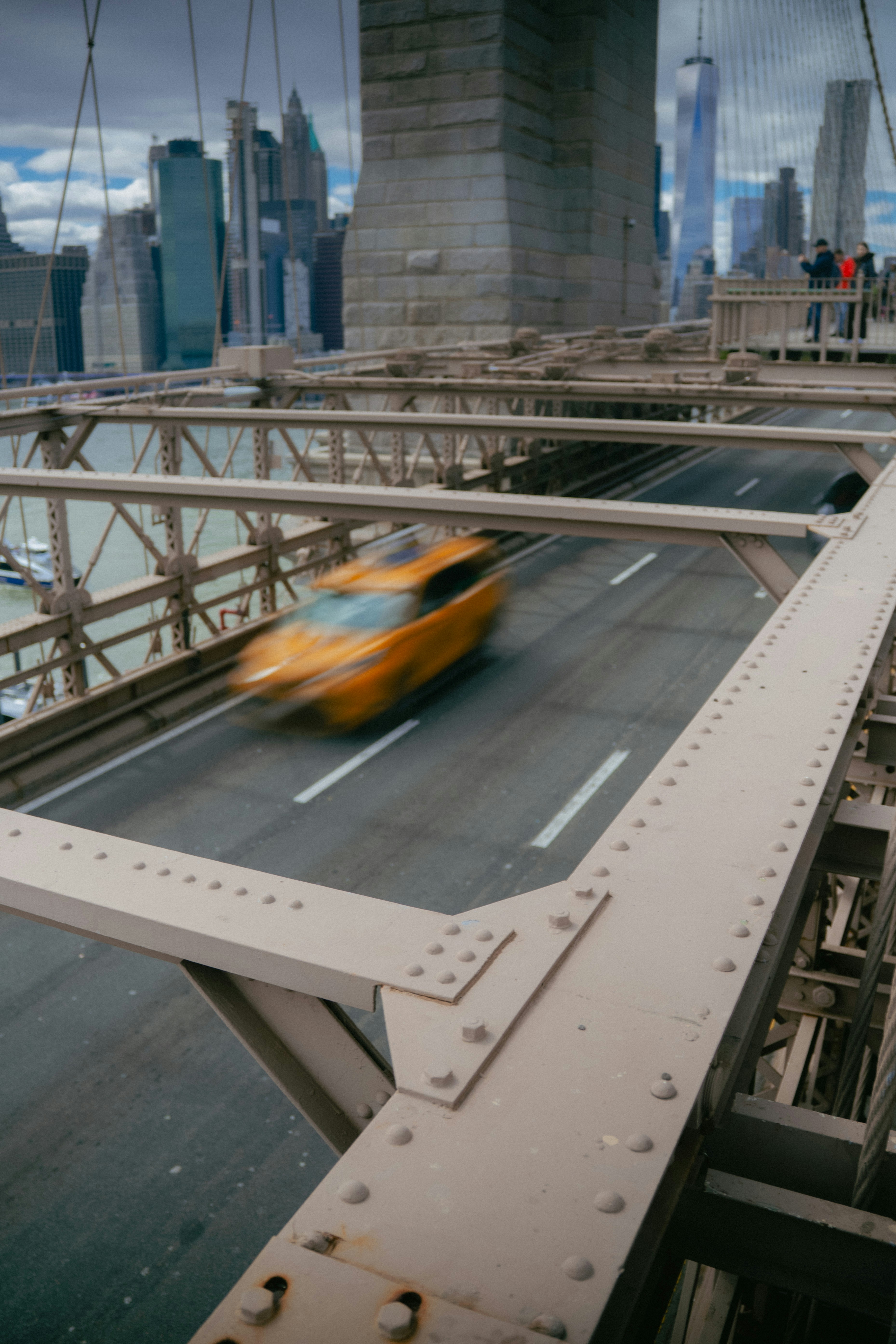 Blue-Sky Blur: Yellow Taxi Traversing the Brooklyn Bridge Toward Manhattan