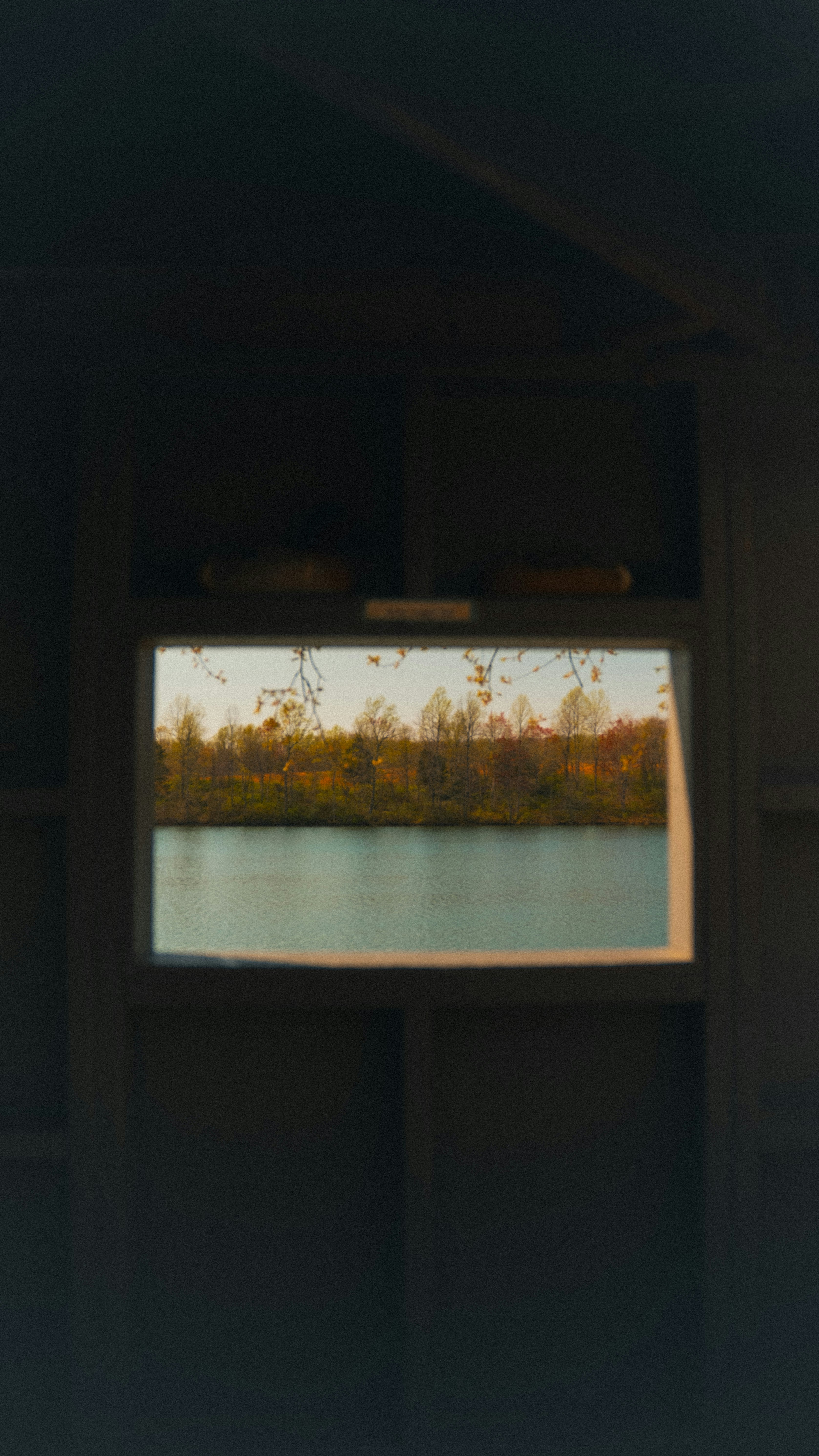 Windowed Autumn: Lake Mirror Beyond a Quiet Corridor